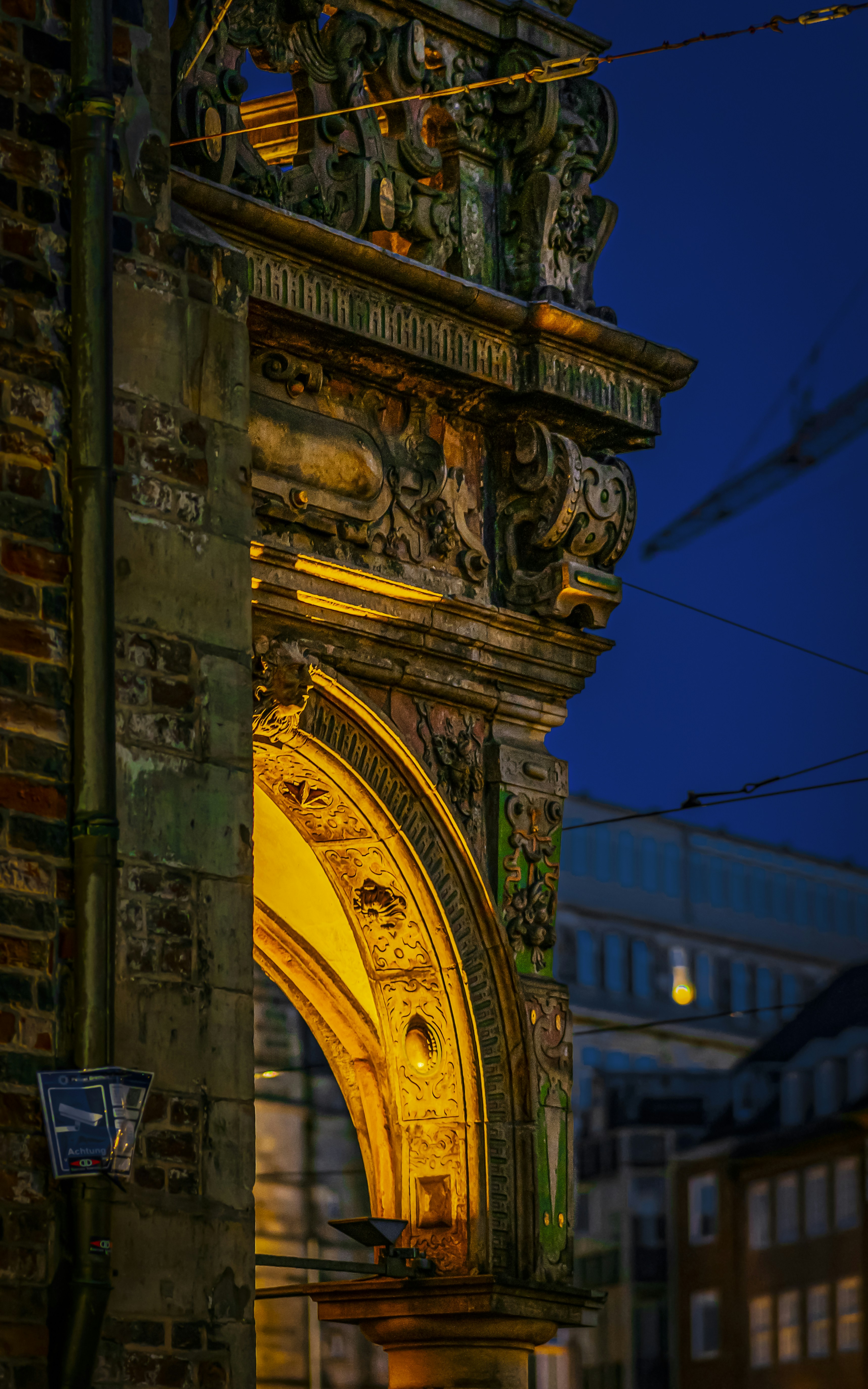 Golden Arch at Night: Warm Carved Gate Framed by Velvet Blue Sky