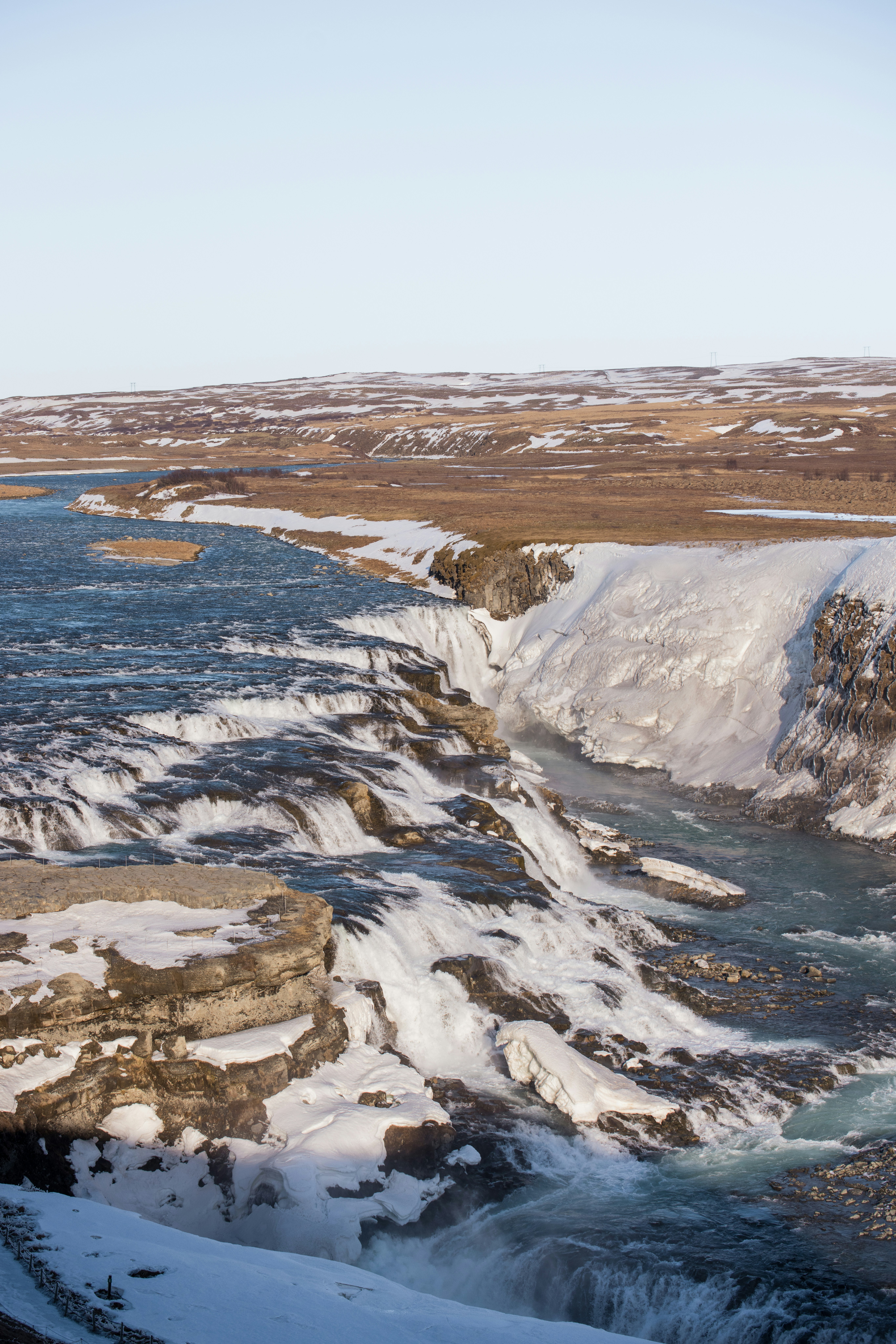 Azure Currents Carve a Snow-Kissed Gorge Under a Quiet Sky