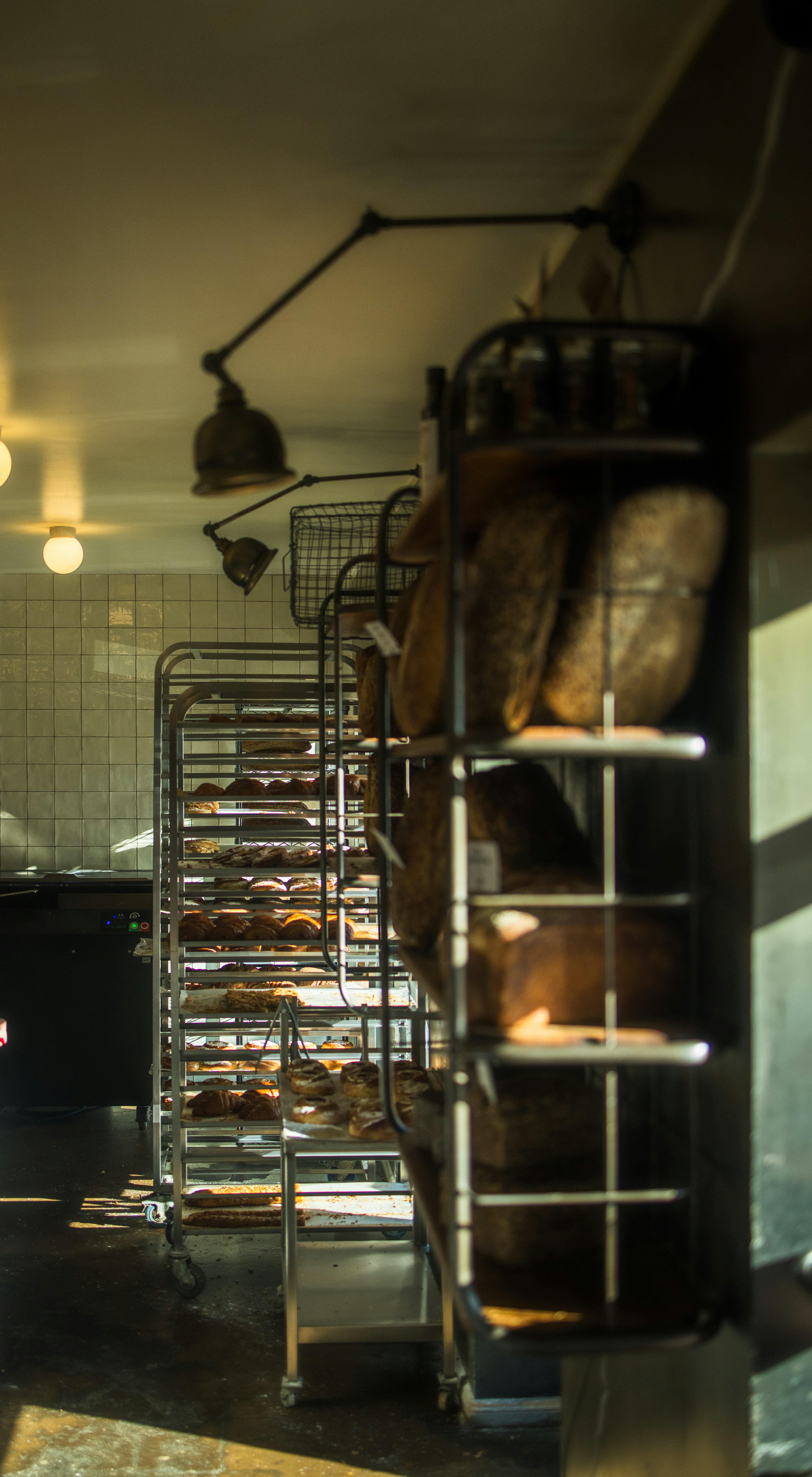 Amber-lit Aisle: Bread Racks Reaching Toward the Back