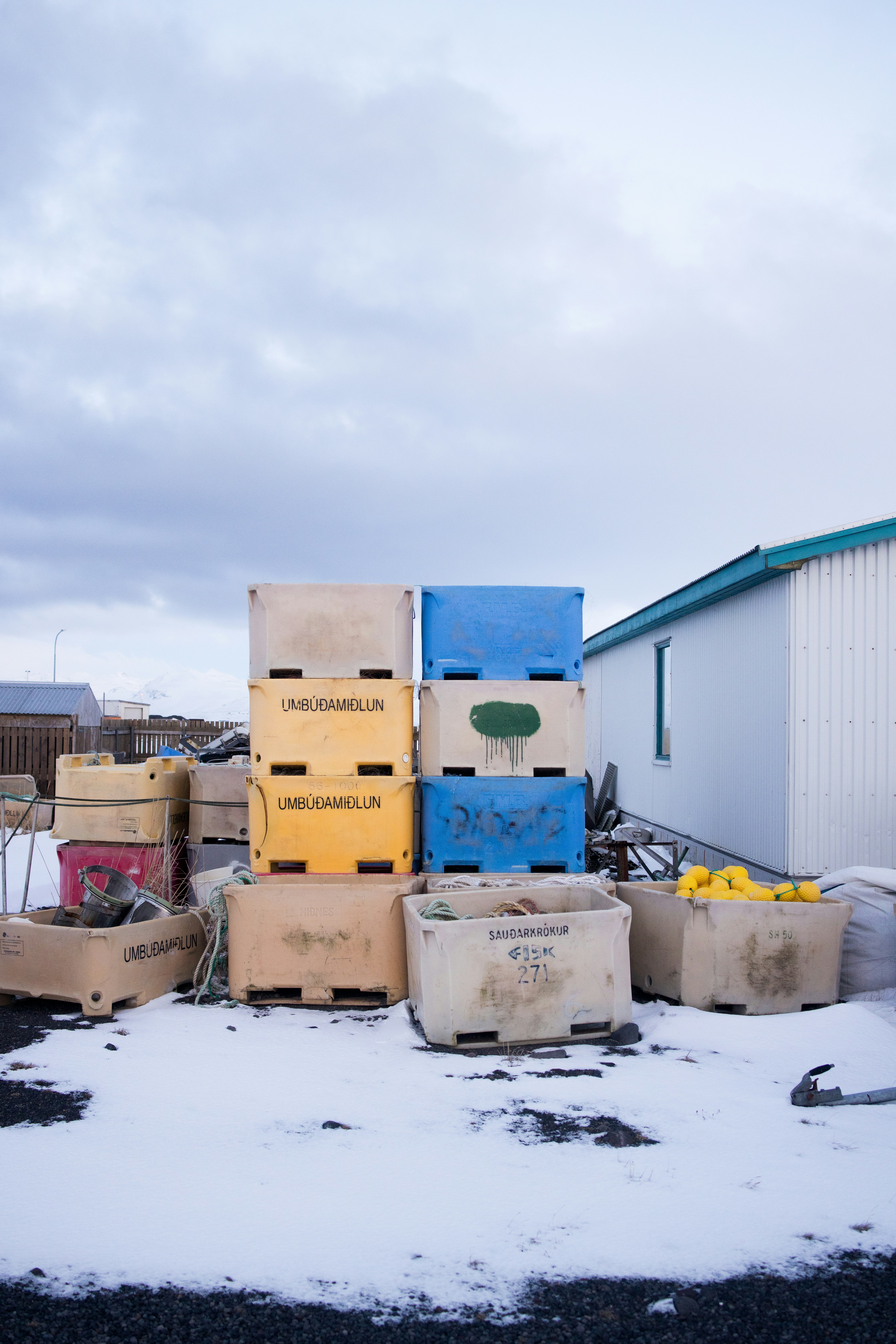 Color-Block Crate Tower in a Snowbound Industrial Yard
