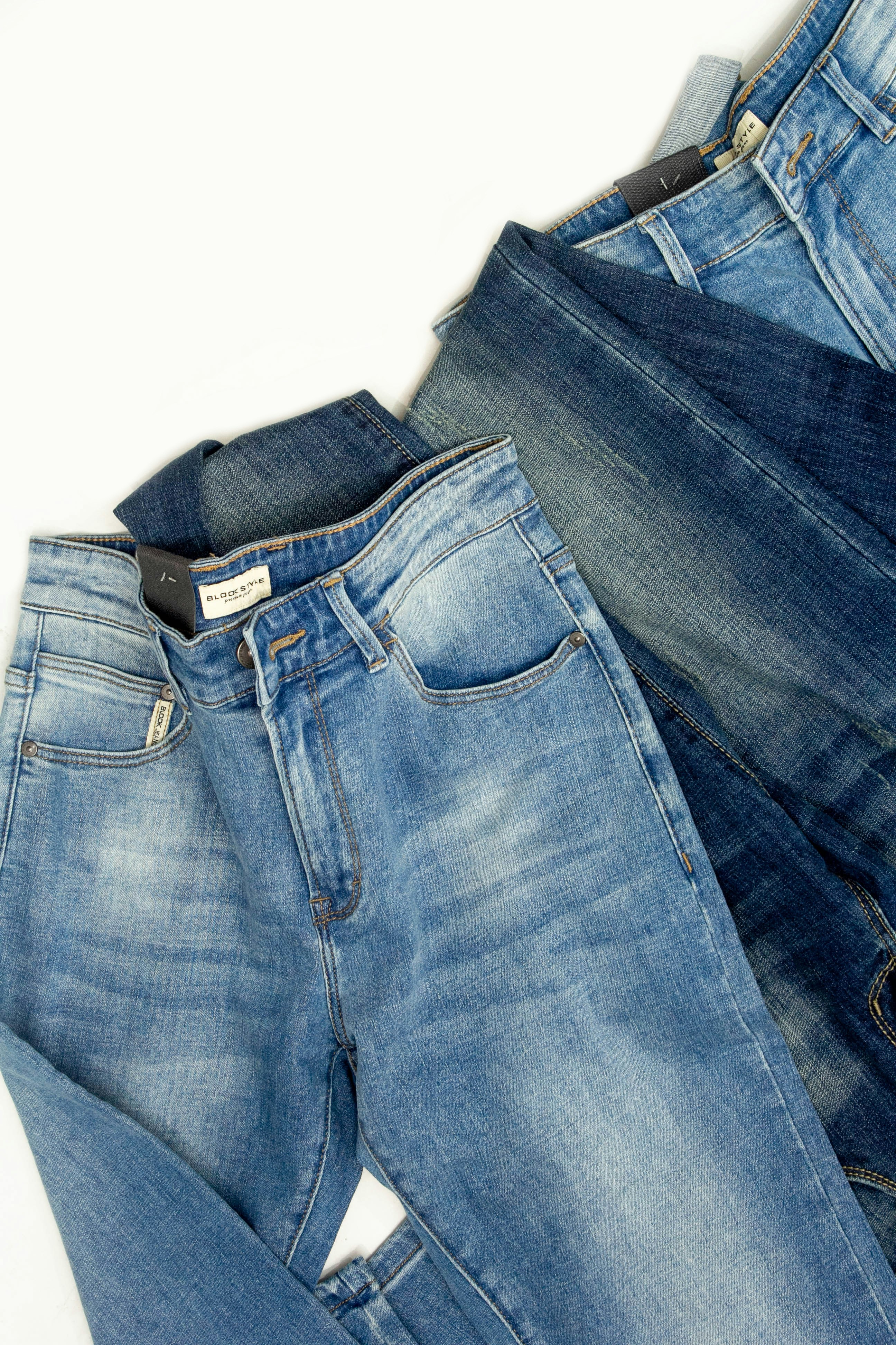 Um par de jeans sentados um em cima do outro foto – Imagem grátis sobre ...