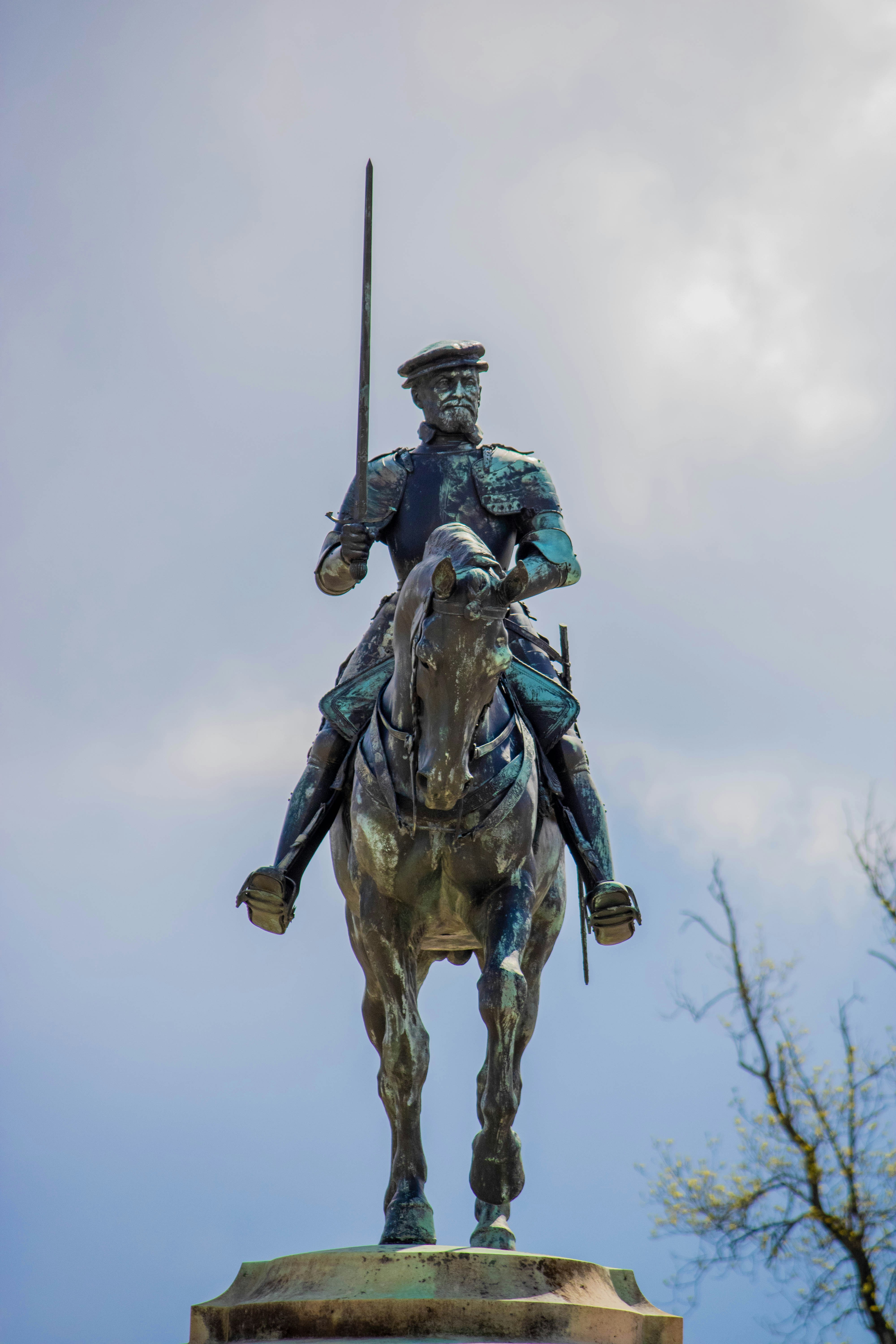 Bronze Sentinel on Horseback: Patinaed Knight Against a Pale Sky