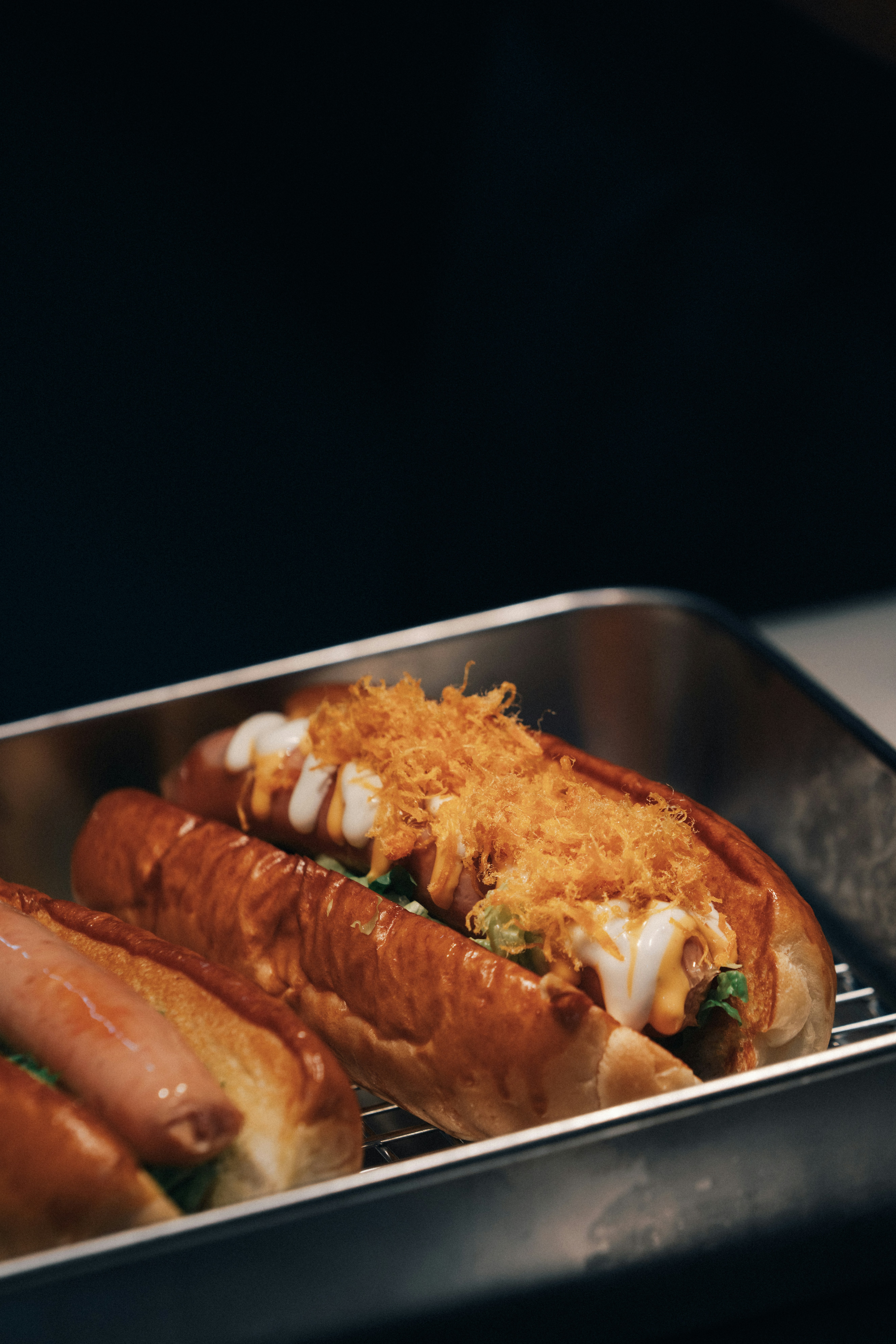 Midnight Grill: Onion-Crowned Hot Dogs on a Stainless Stage