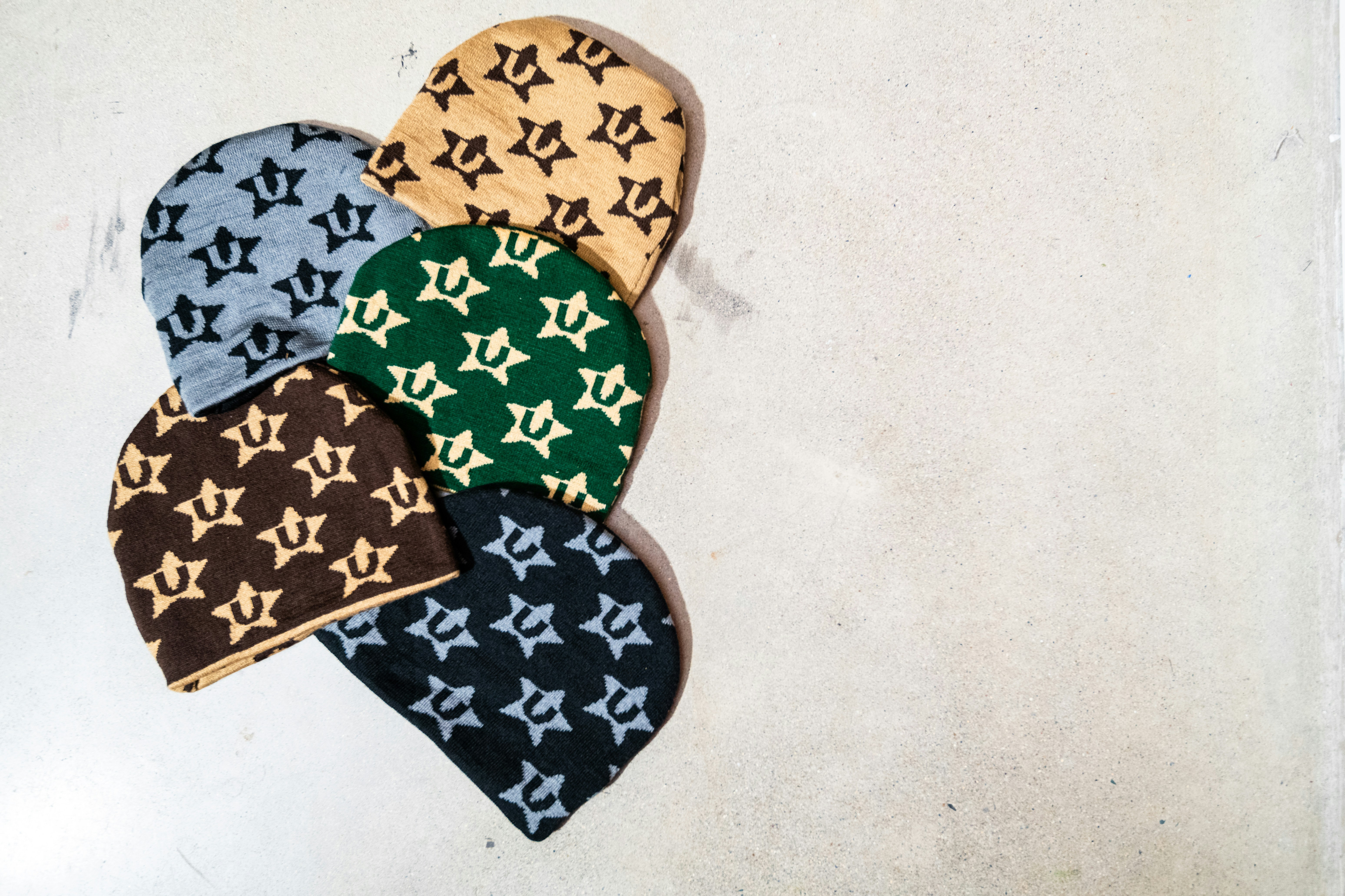Logo-Pattern Guitar Picks in a Color-Fanned Ensemble on Pale Concrete