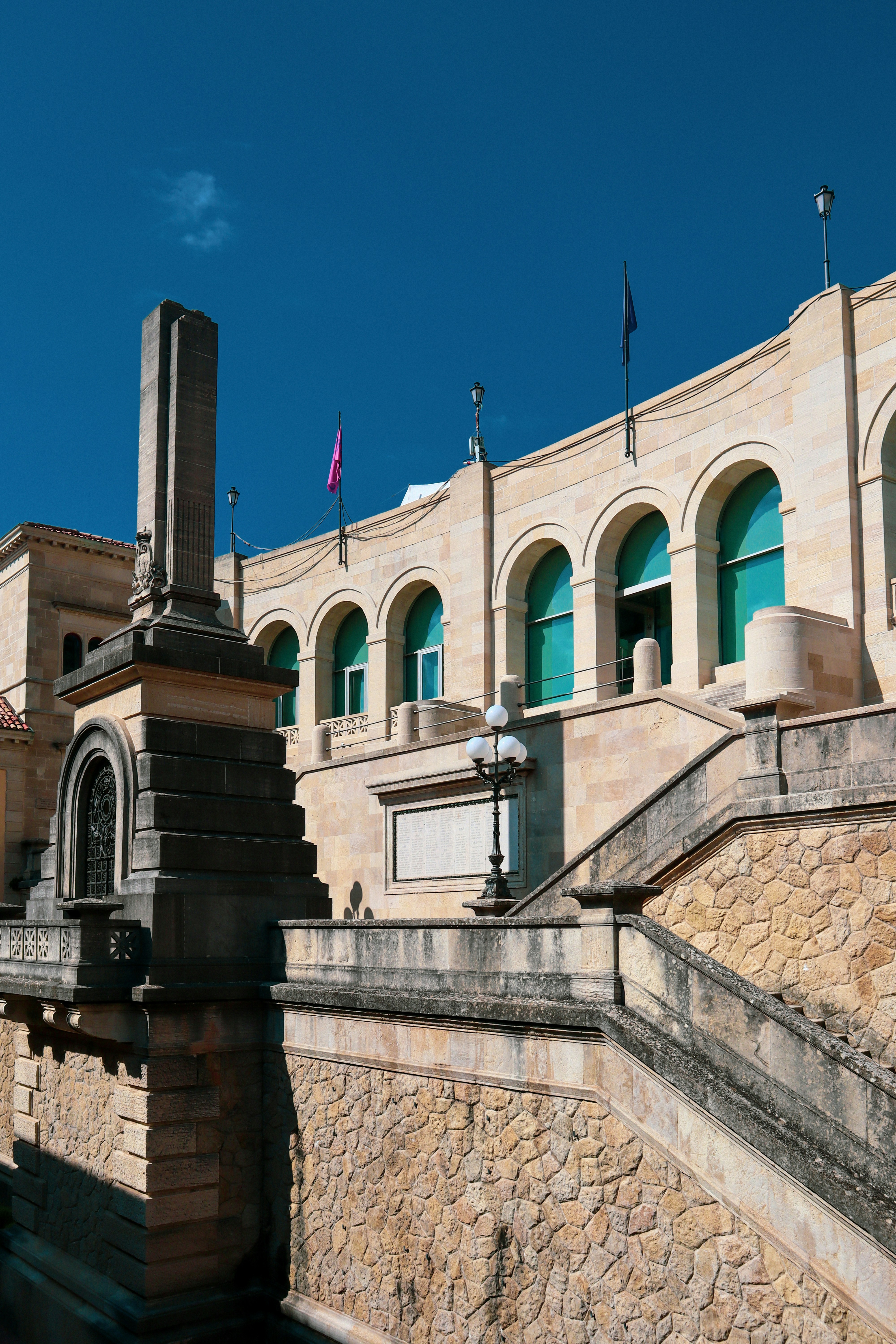 Arcaded Terrace Beneath a Cerulean Sky: Green Arches and a Monumental Staircase