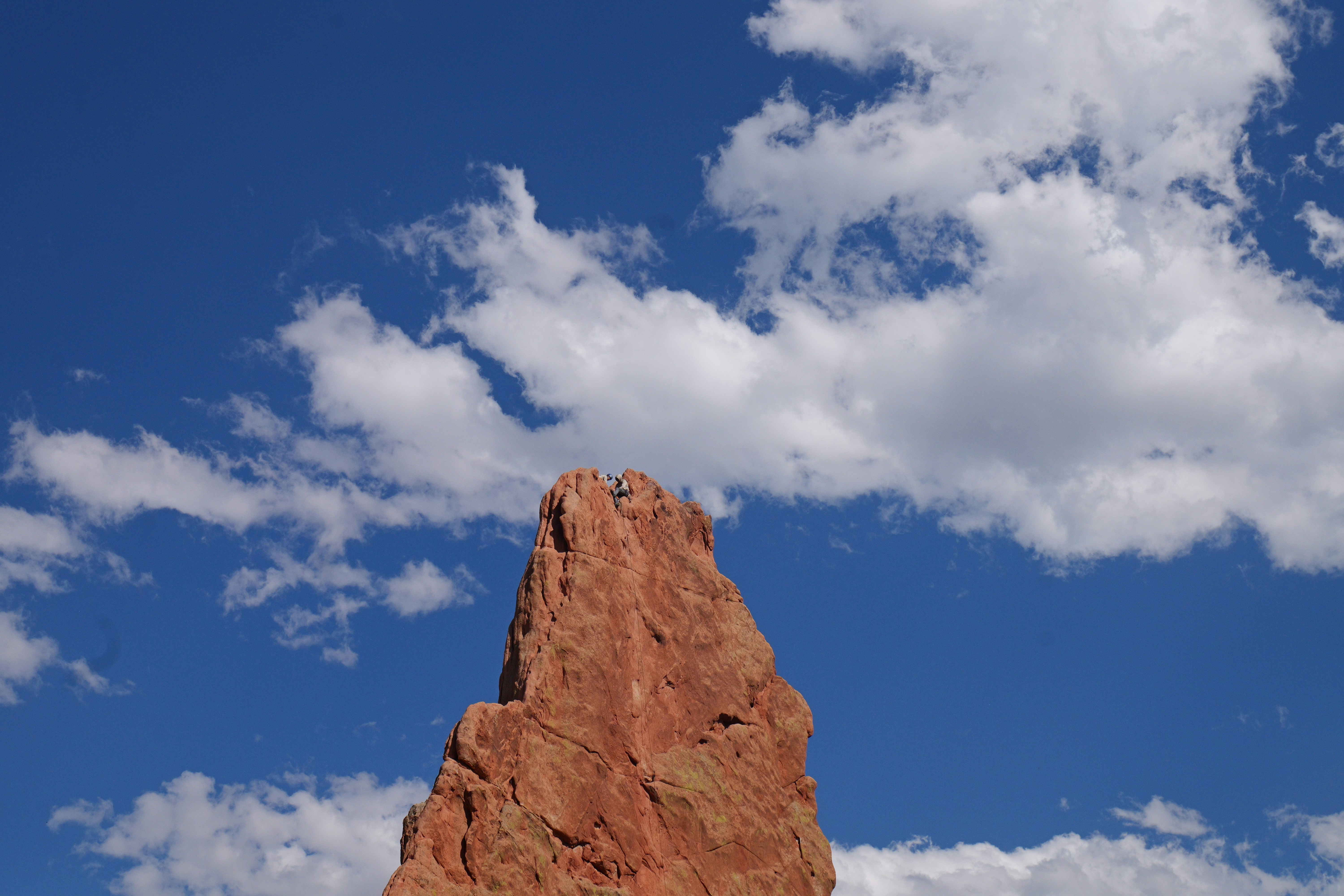 Crimson Spire Against a Cloud-Swept Blue Sky