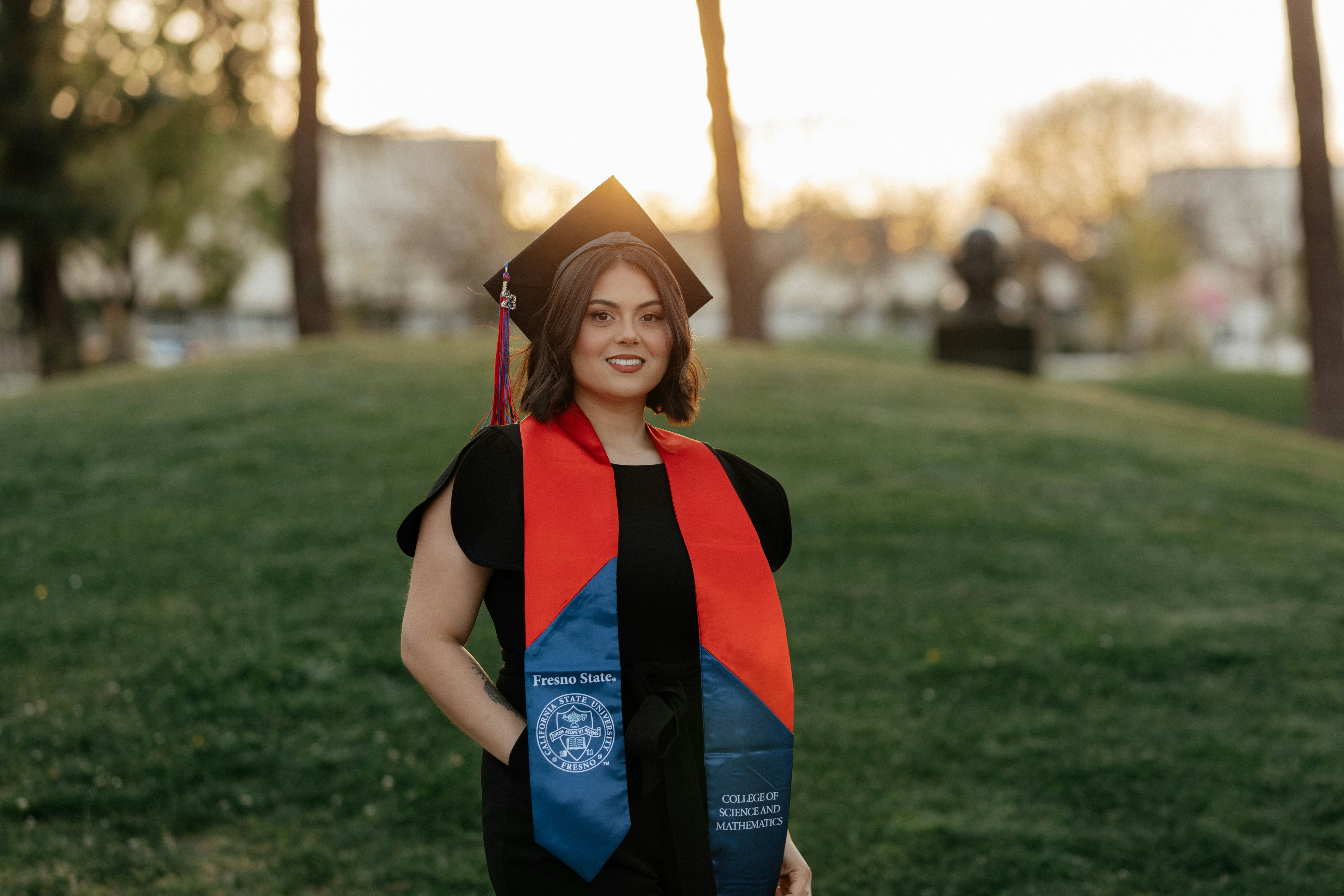 A woman in a graduation cap and gown posing for a picture