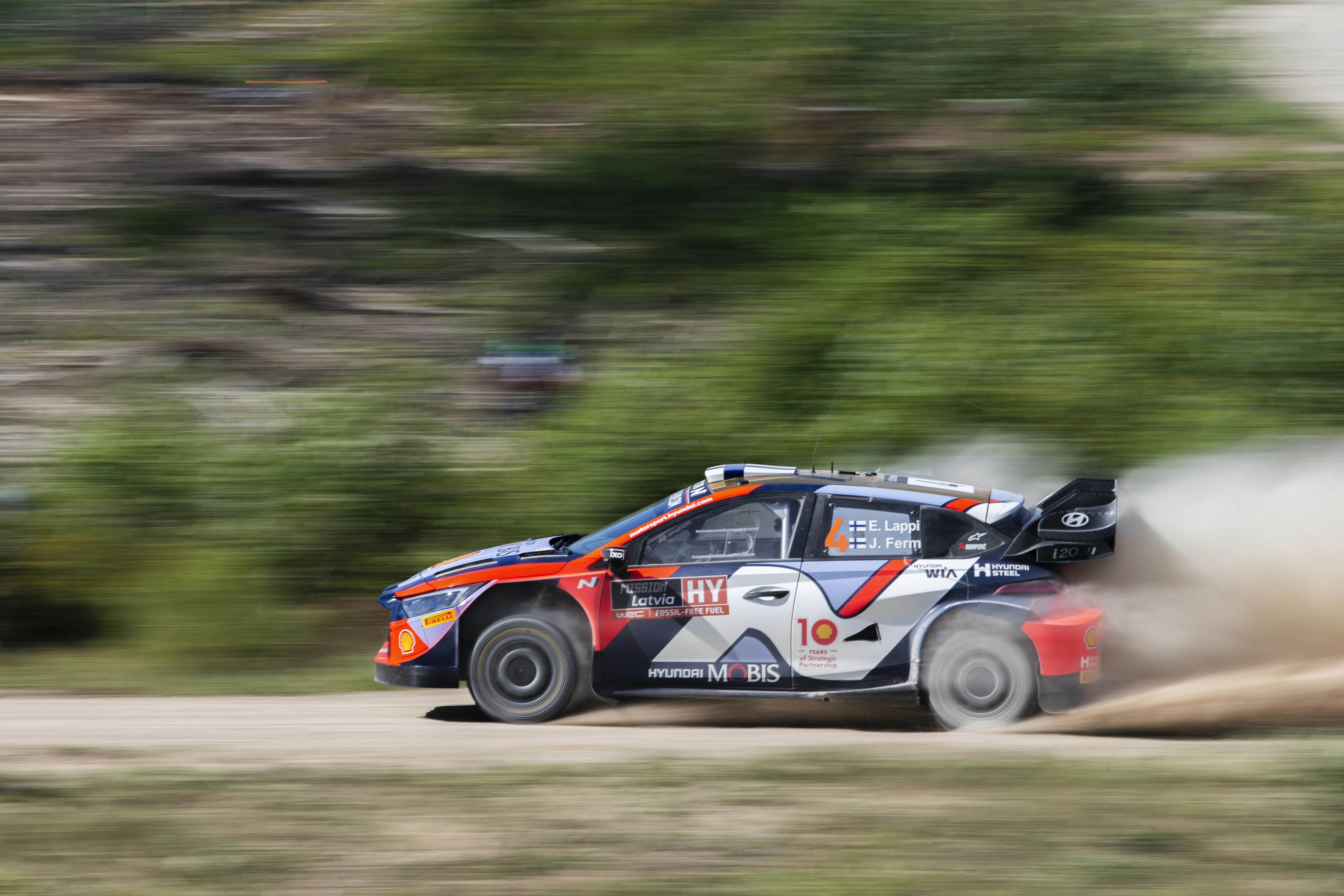 A car driving down a dirt road with trees in the background photo ...