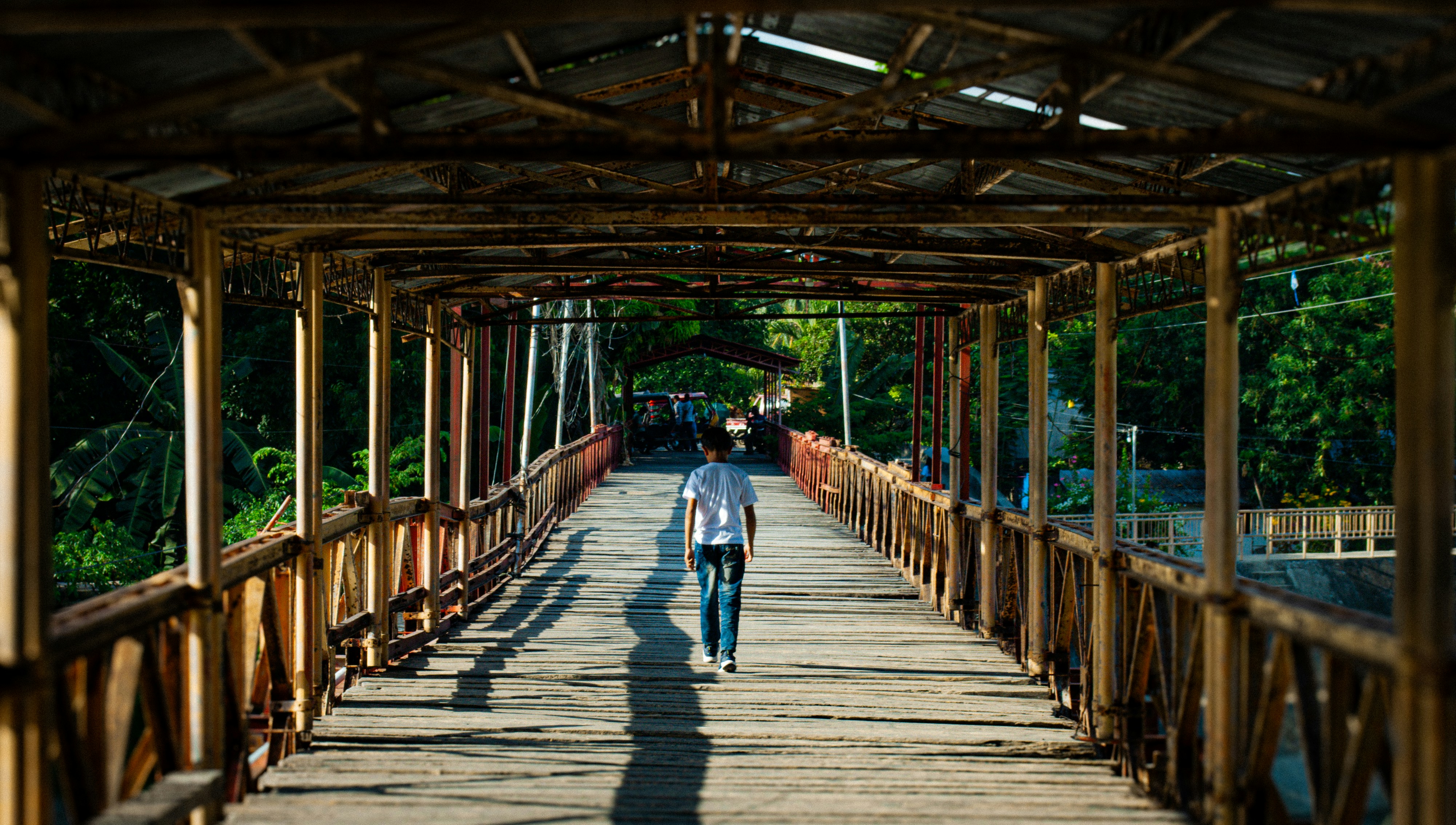 A boy walking on a Rusty Old Bridge
