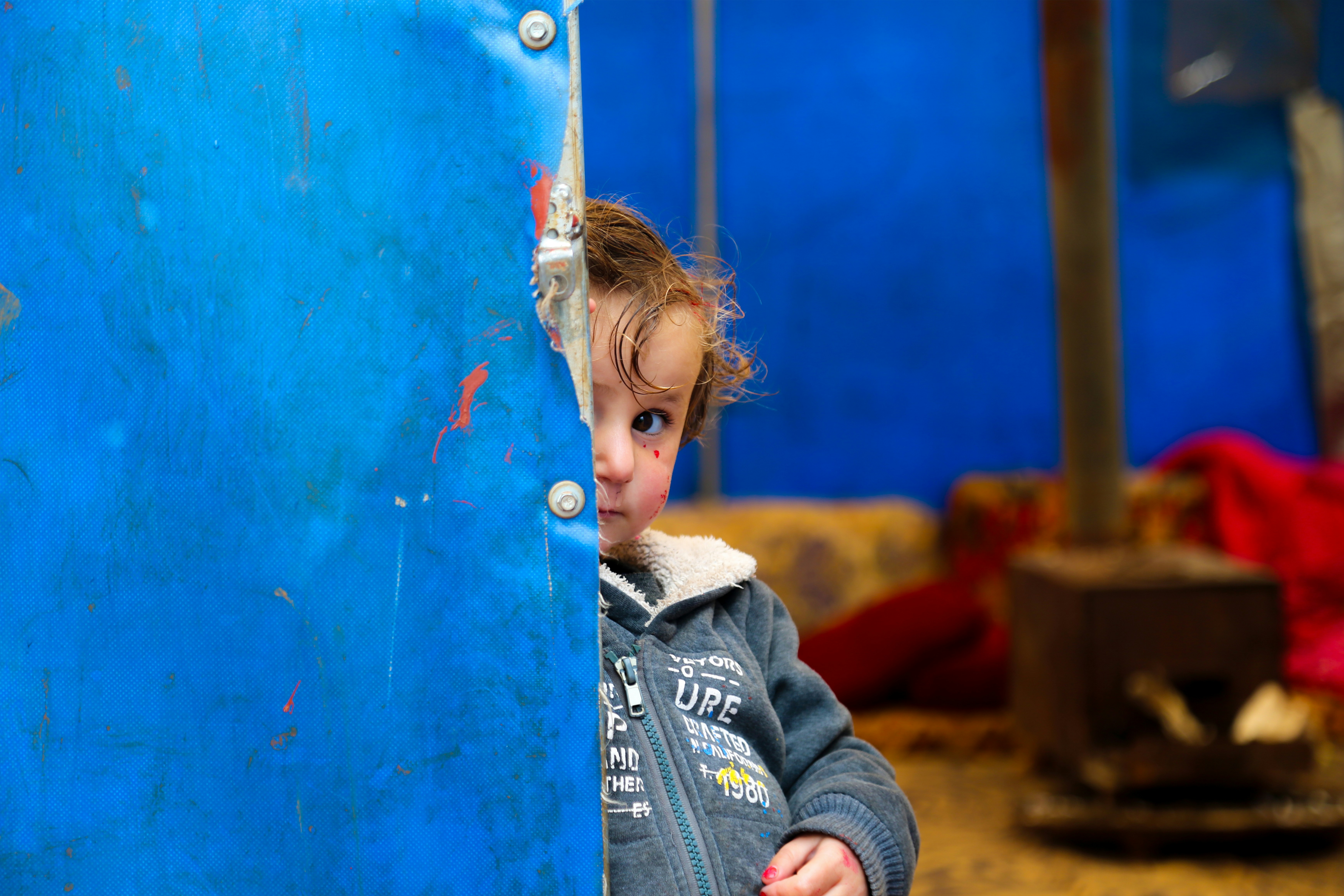 Hidden Gaze Behind Weathered Blue Panel
