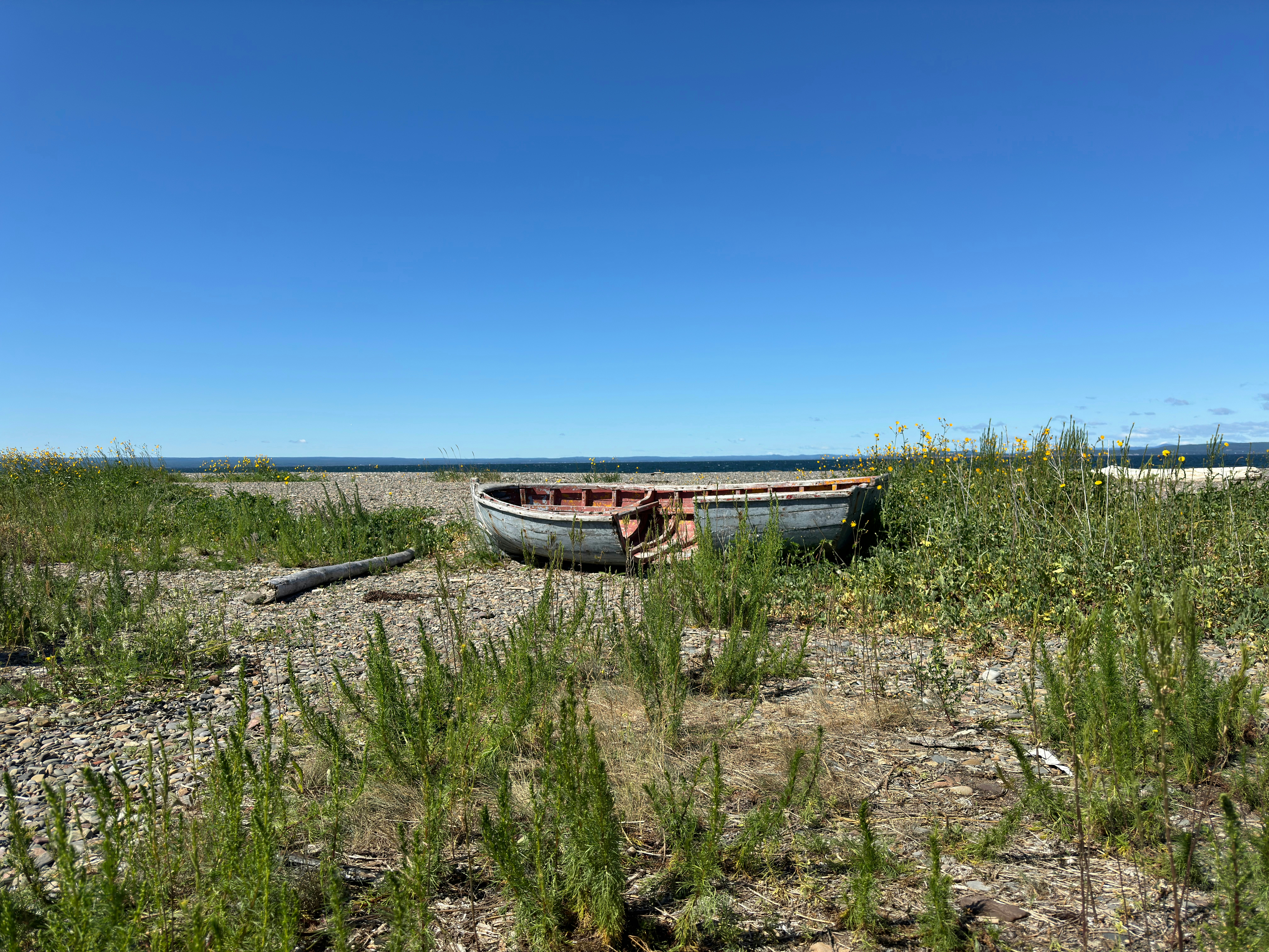 Weathered Rowboat on a Sparse Dune, Quiet Sea at the Horizon