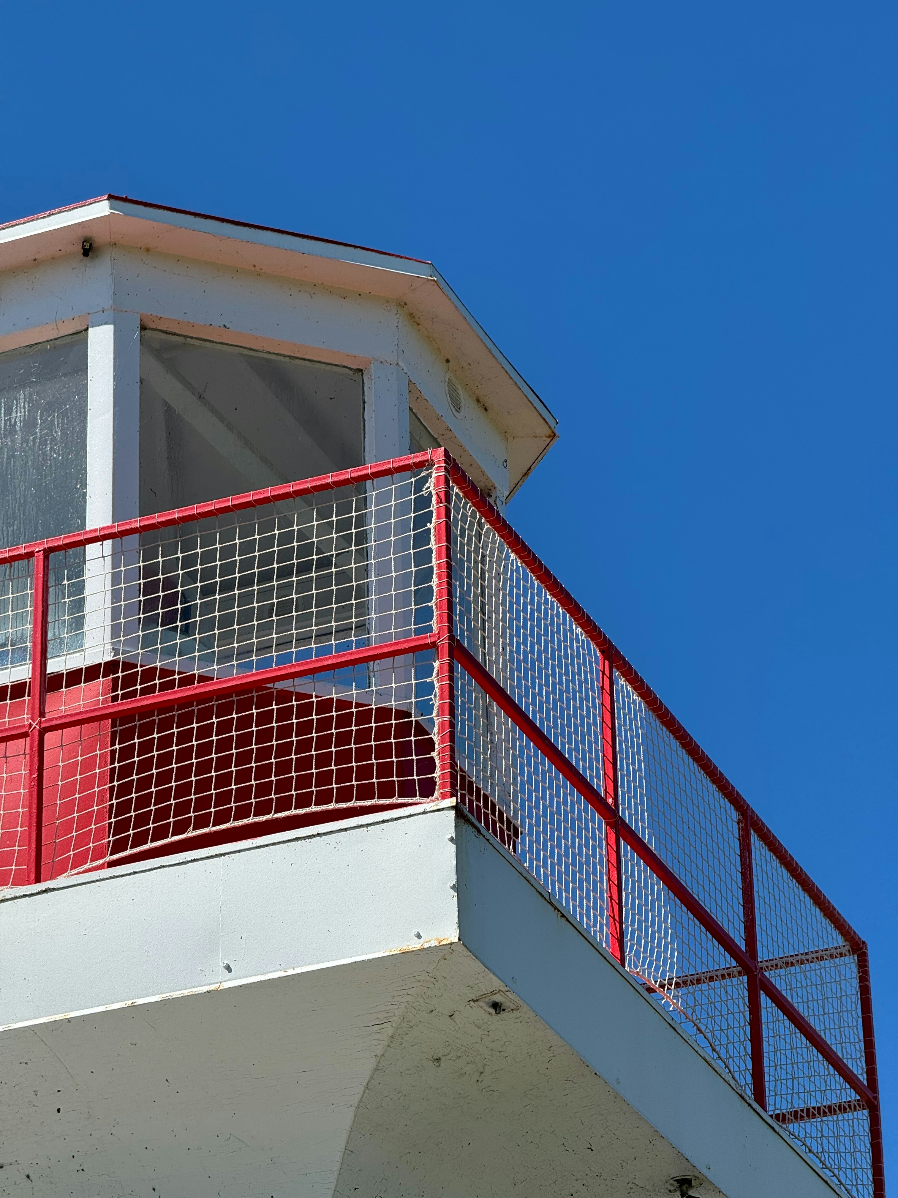 Crimson Guardrail Framing a White Lookout Beneath a Pristine Blue Sky