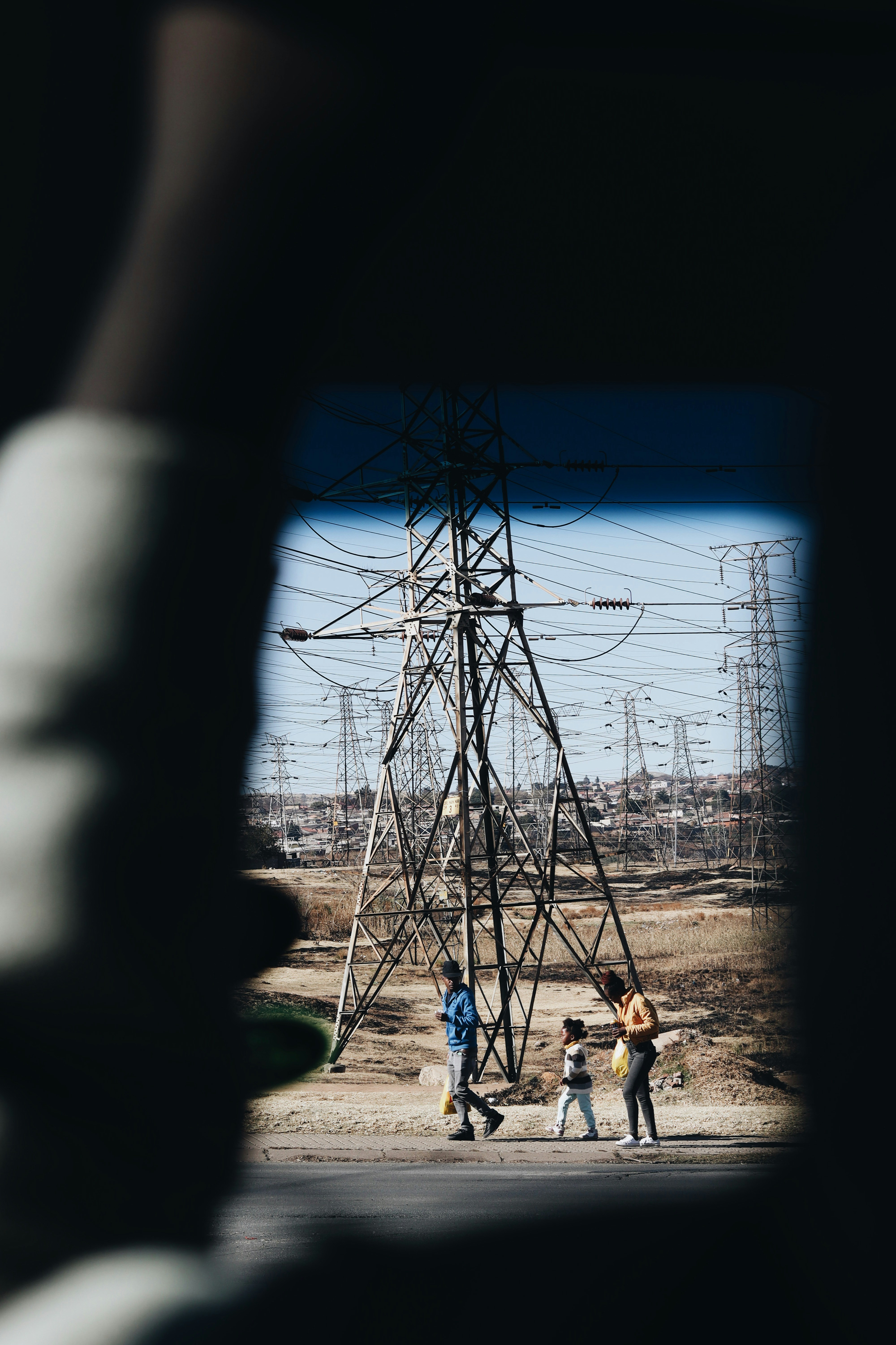 Through the Frame: Children Crossing Under Power Lines