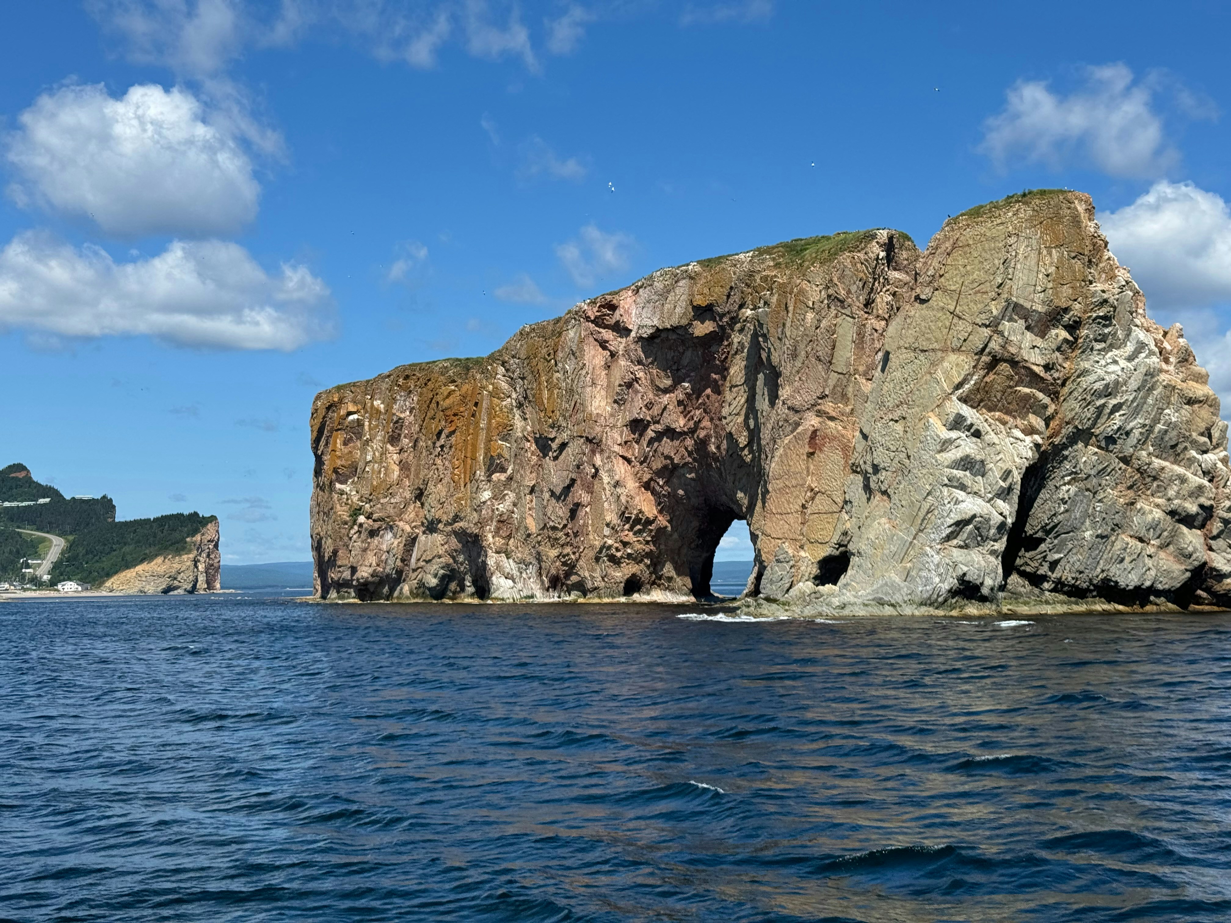 Sea Arch Emerges from the Cliff: A Coastal Rock Formation under a Clear Blue Sky