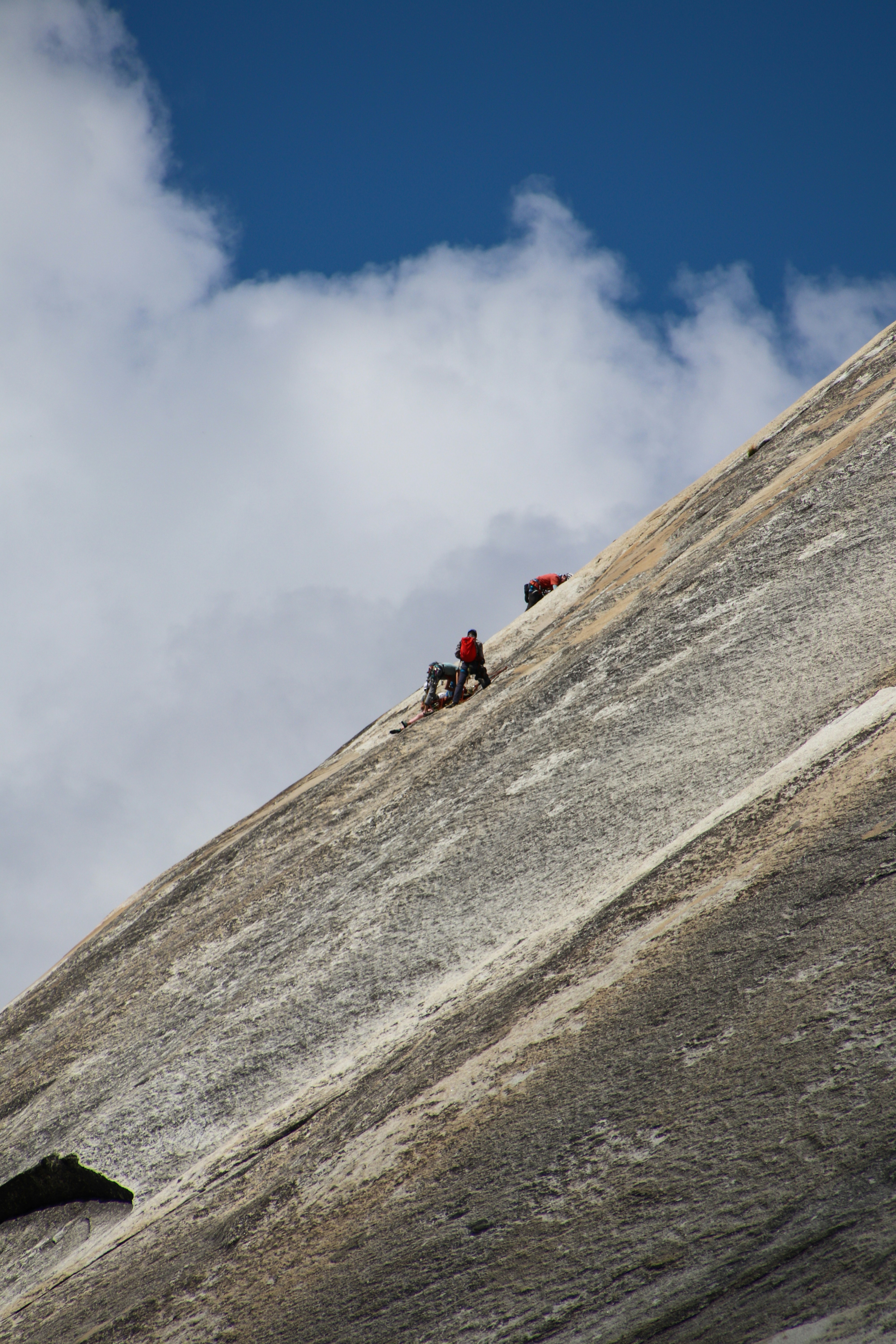 A group of people climbing up the side of a mountain photo – Free ...