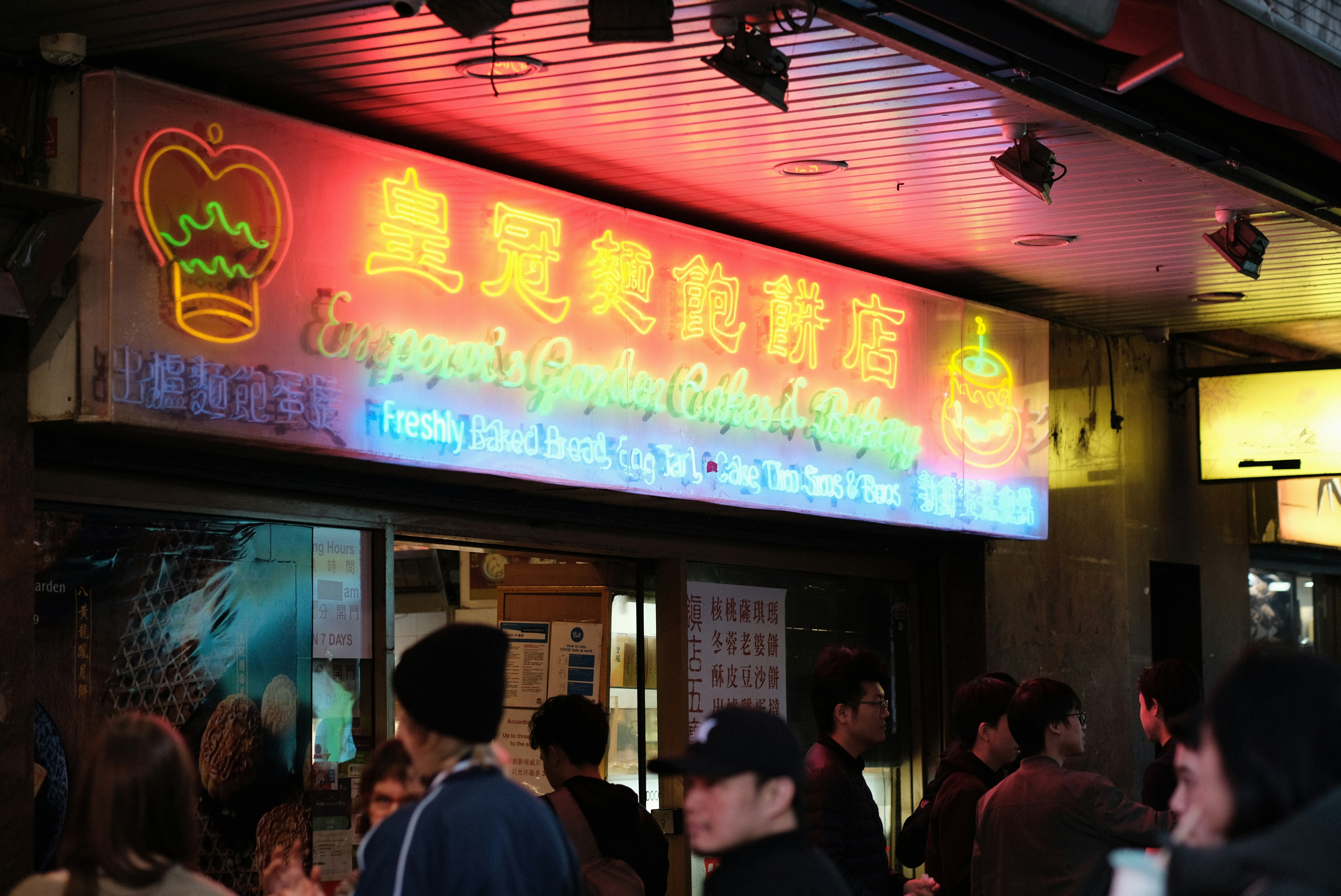 Neon Signage Illuminates a Busy Night Market Entrance