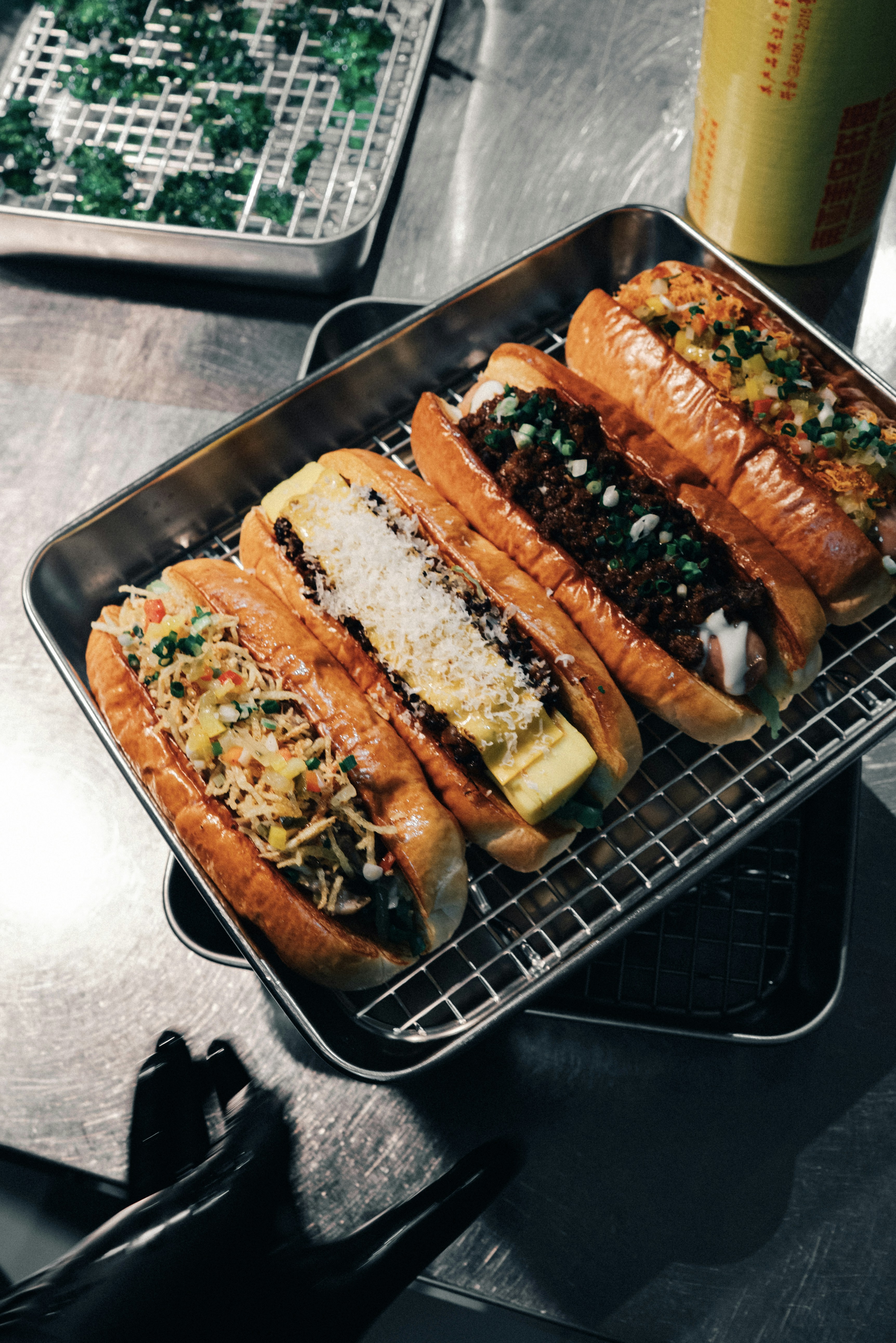 A Row of Gourmet Hot Dogs on a Gridded Tray