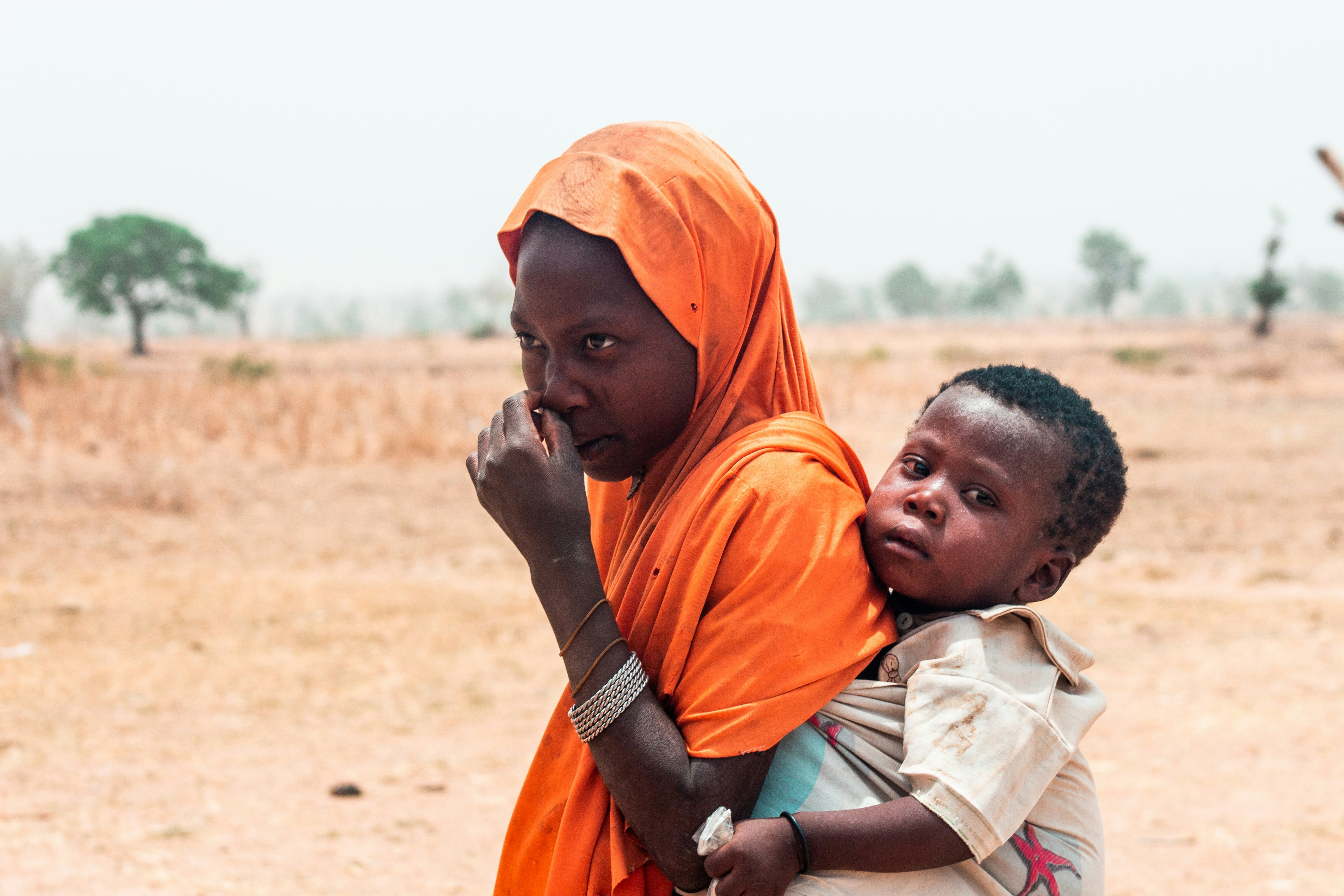 A woman carrying a child on her back photo – Free Boy Image on Unsplash