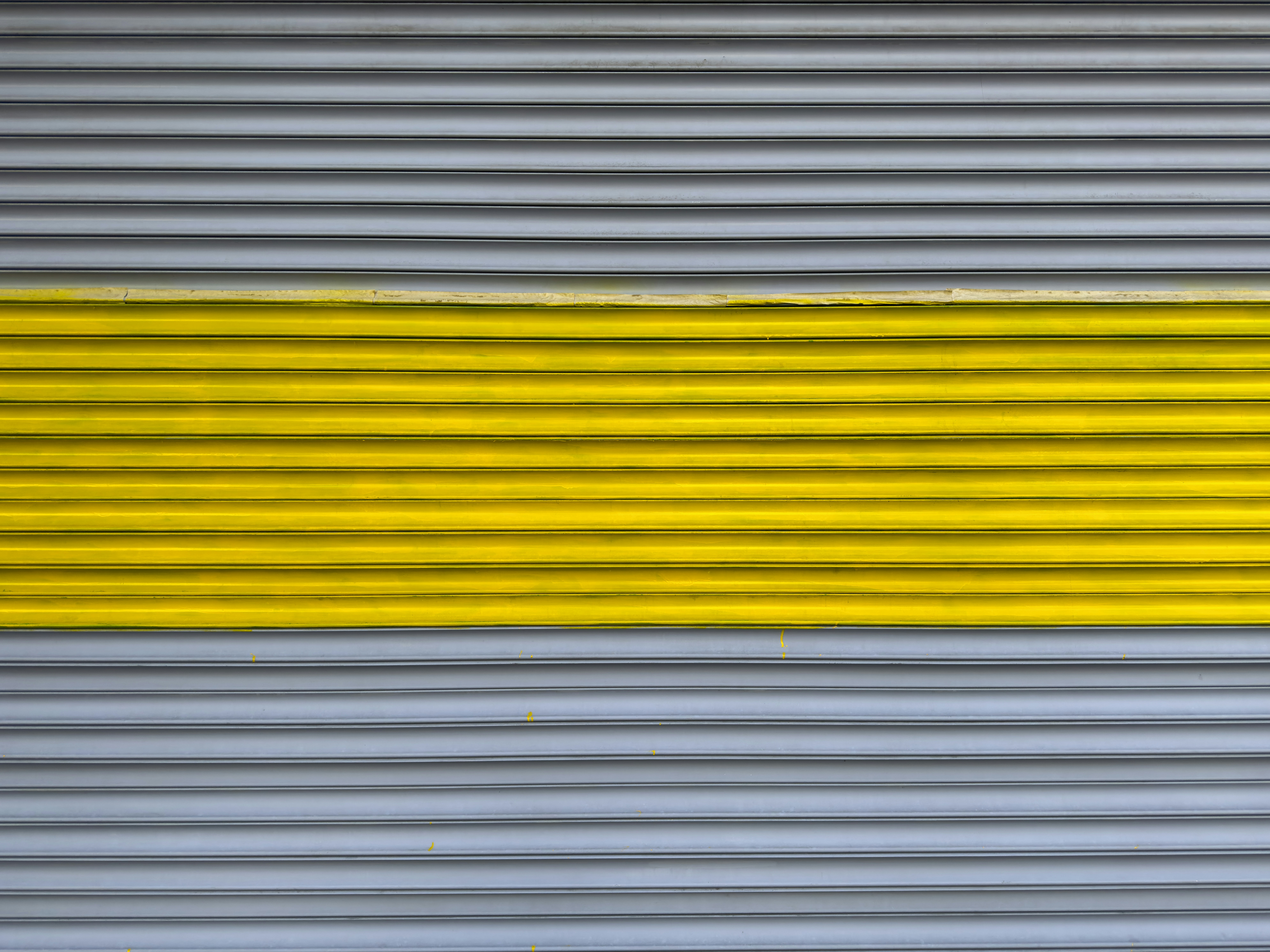 Yellow Band Across Blue-Grey Corrugation: Minimalist Industrial Rhythm
