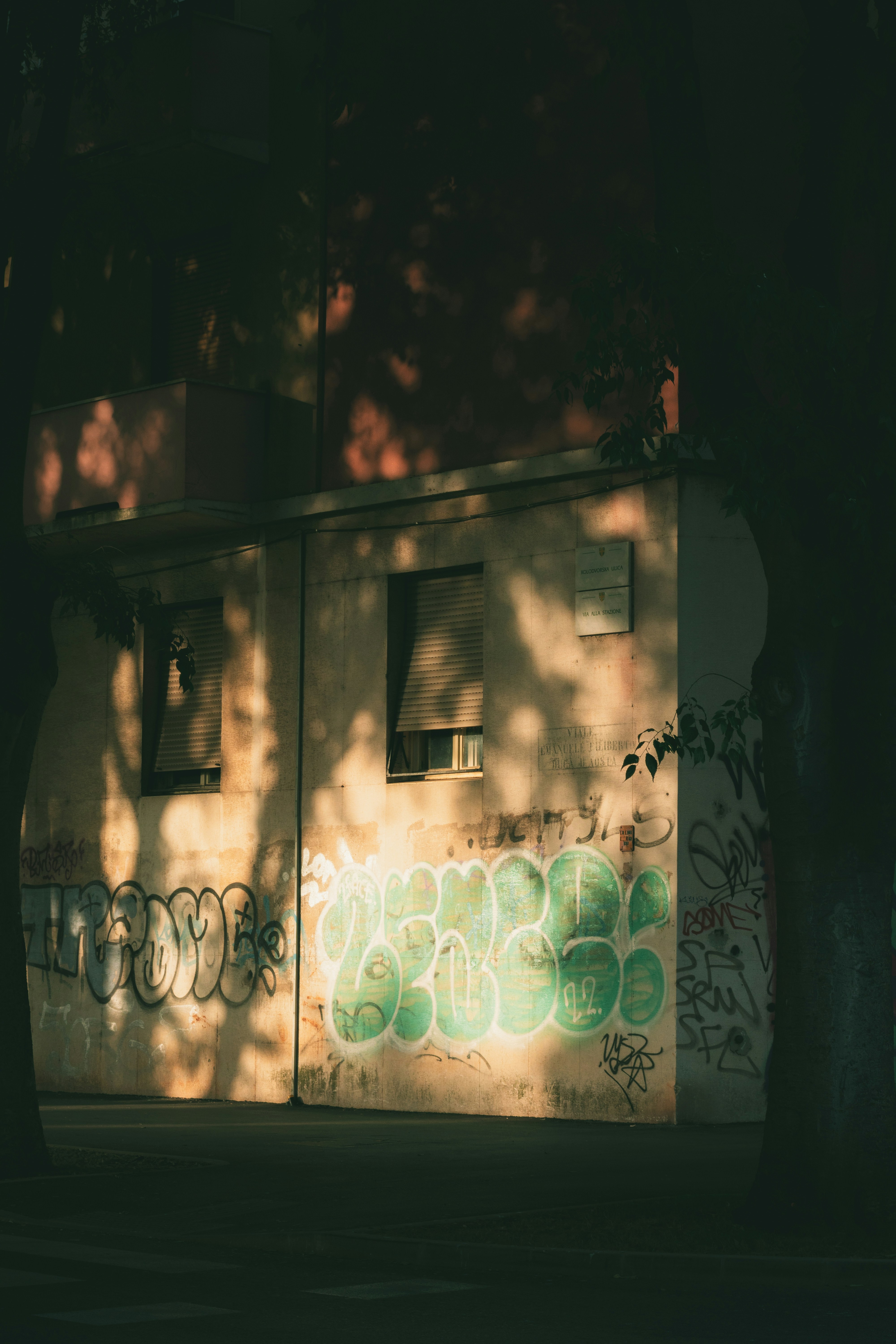 Patchwork Shadows over a Graffiti-Washed Facade