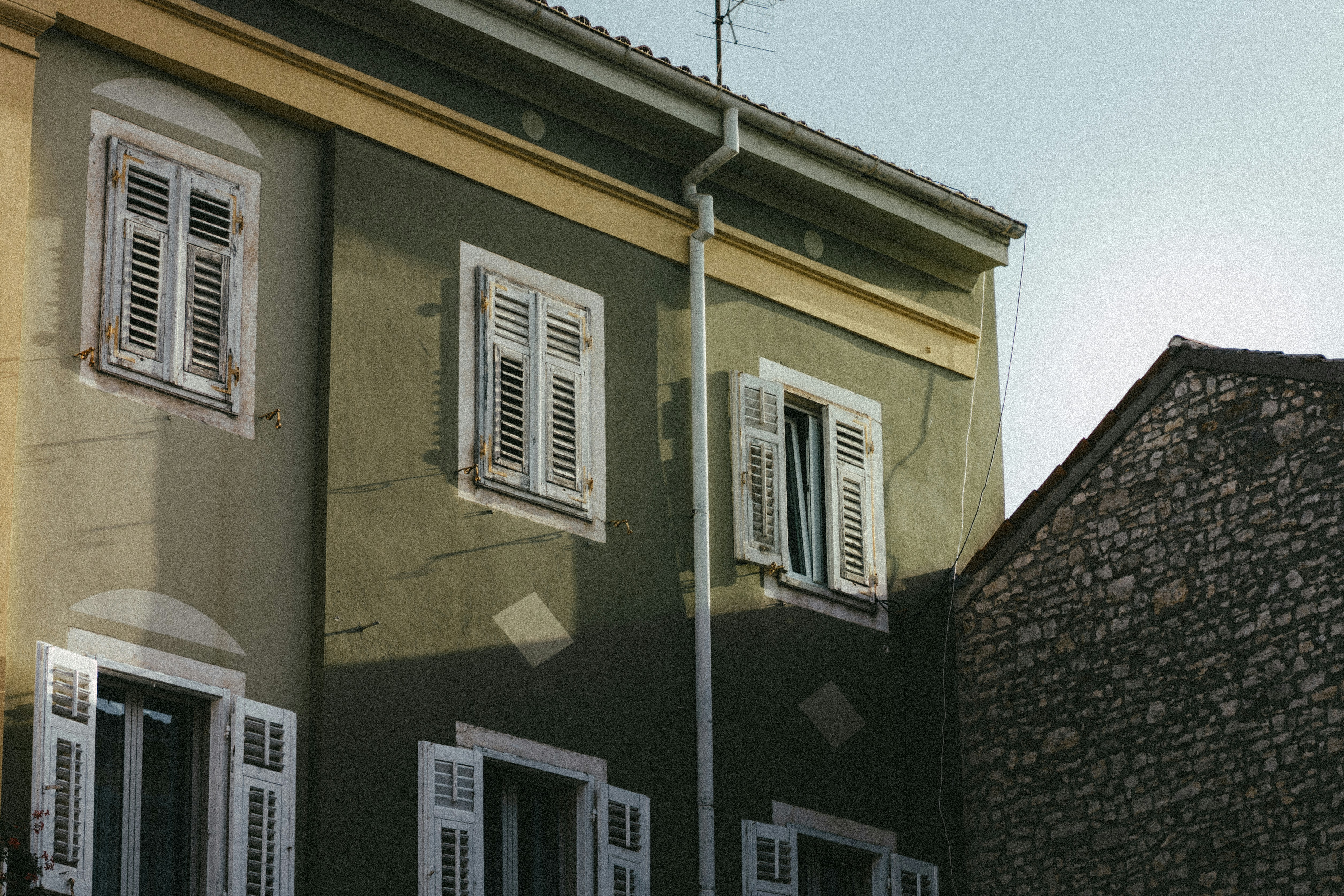 A row of buildings with windows and shutters photo – Free Croatia Image ...