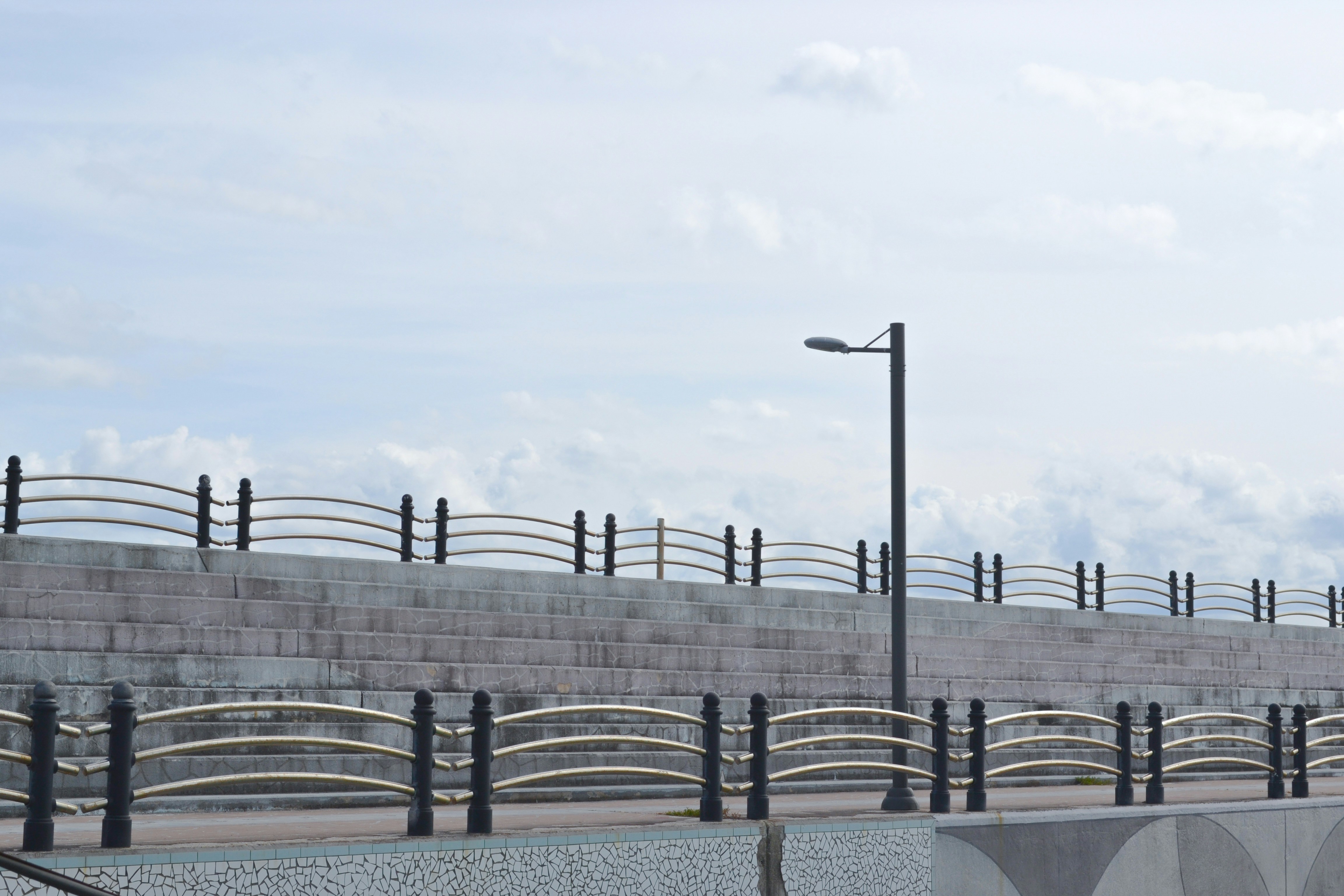 Lone Lamp Above Curved Promenade: A Quiet Waterfront Scene