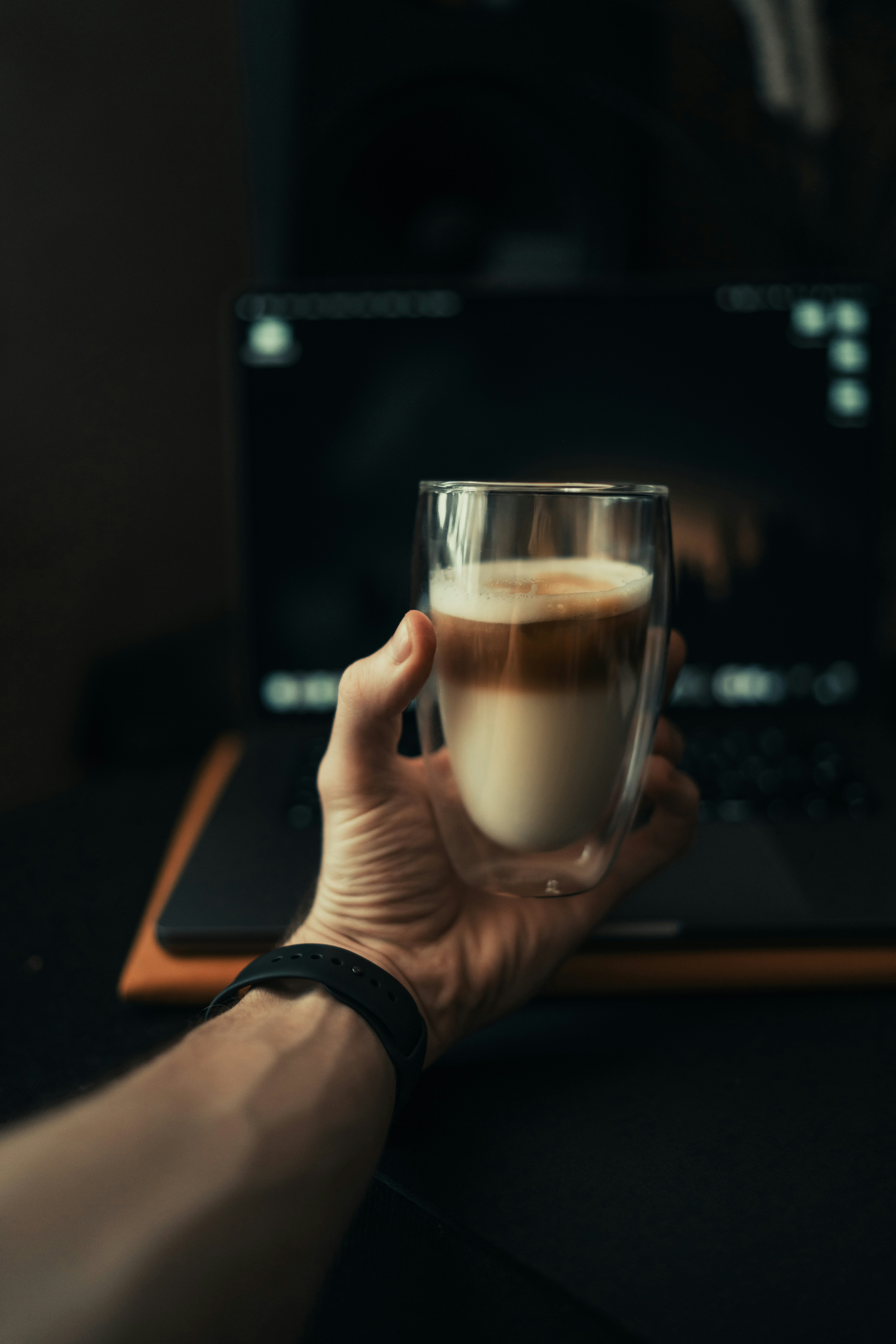 A person holding a glass of coffee in front of a laptop photo – Free Coffee Image on Unsplash