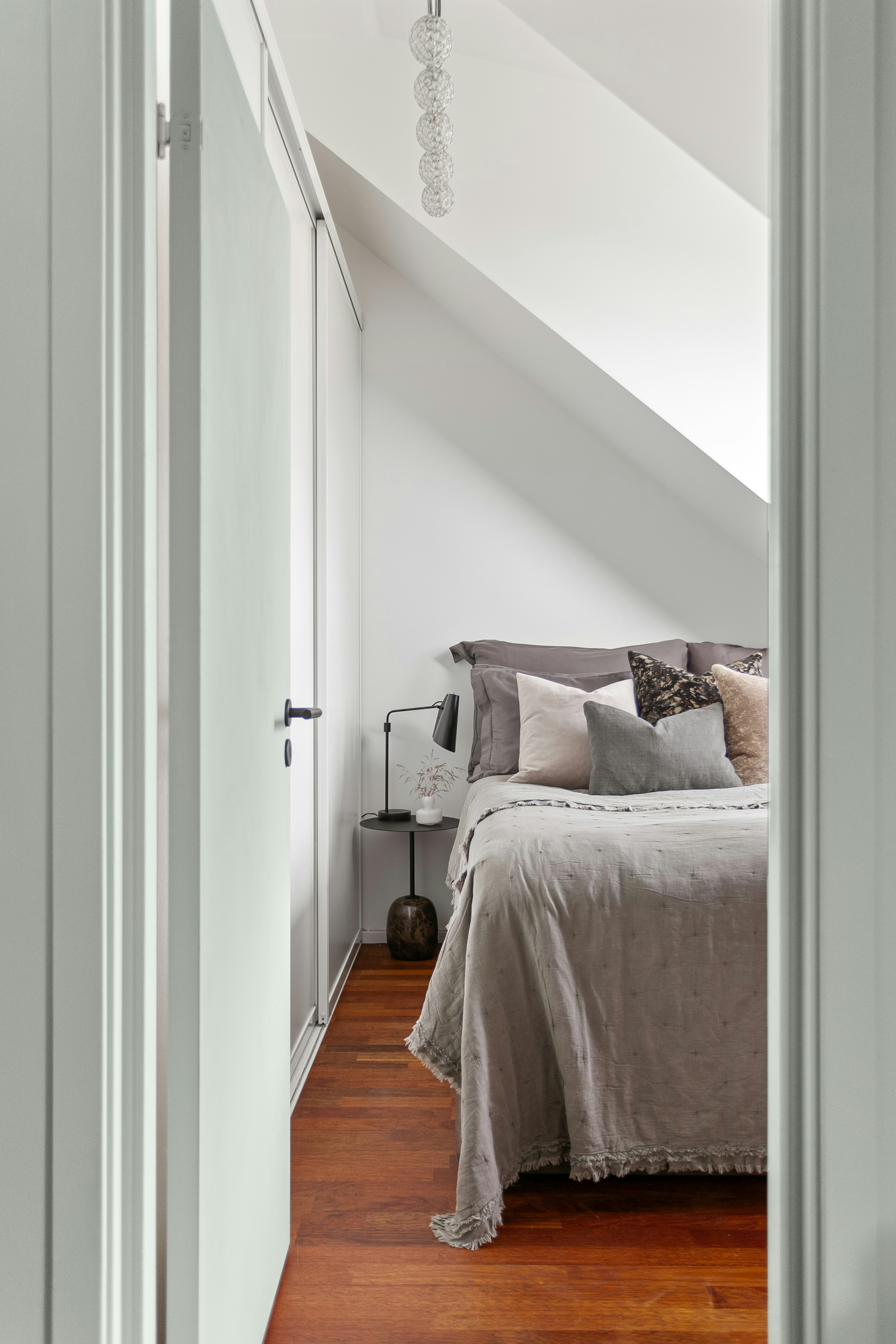 A bedroom with a bed sitting under a slanted ceiling photo – Free ...