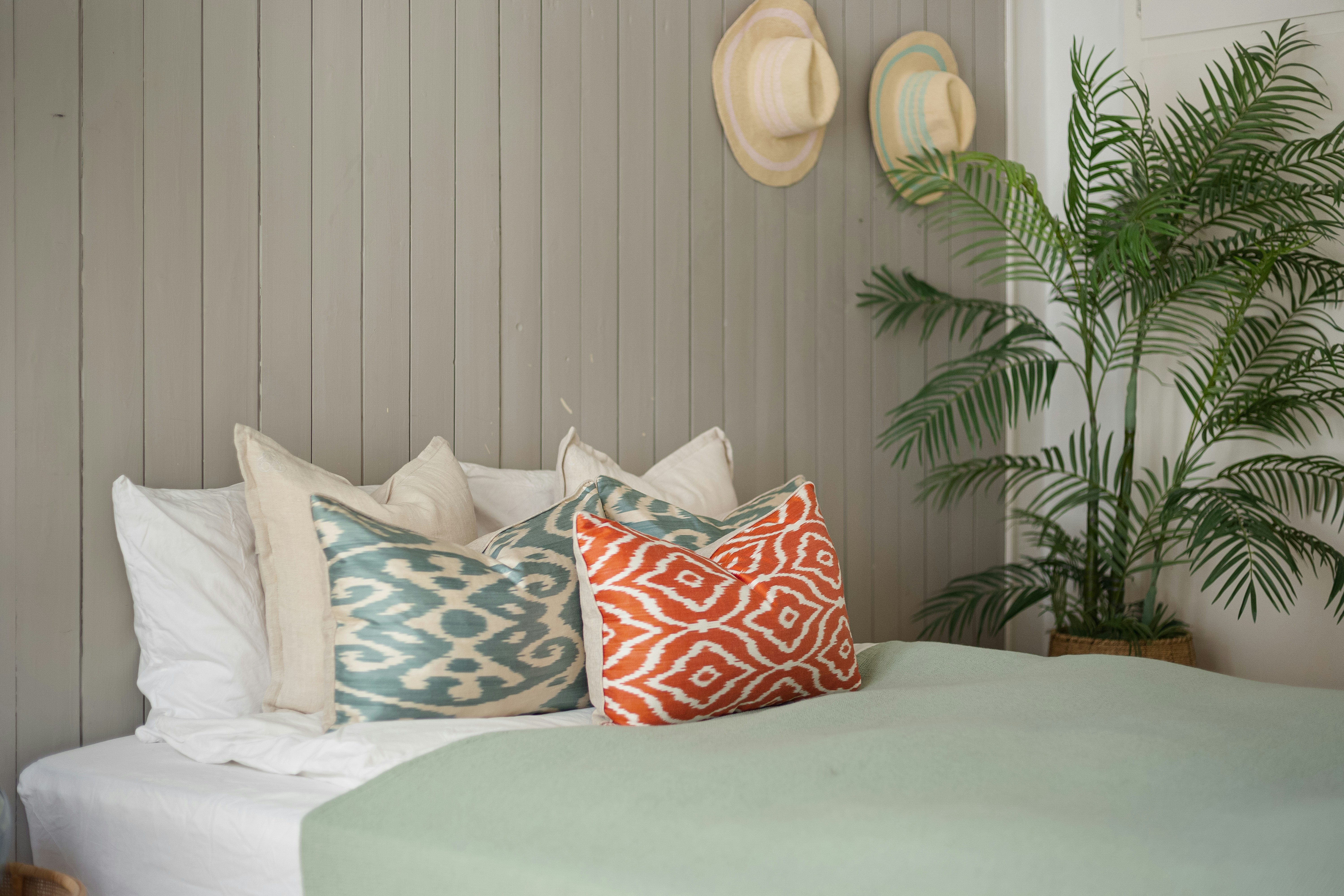 Sunlit Comfort: A Cozy Bedside Moment with Decorative Cushions