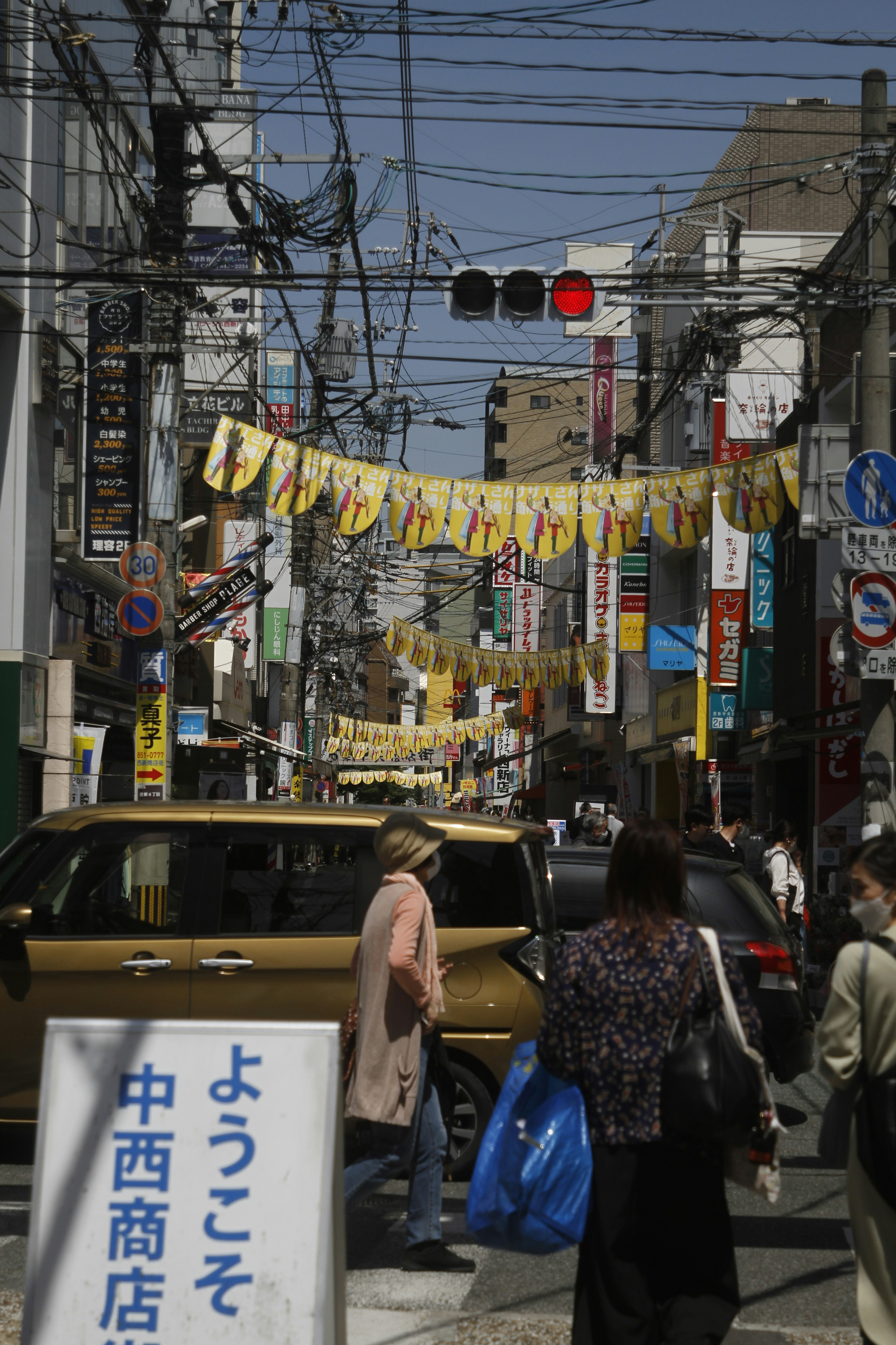 Wired Corridor: A Sunlit Japanese Street Threaded with Yellow Banners