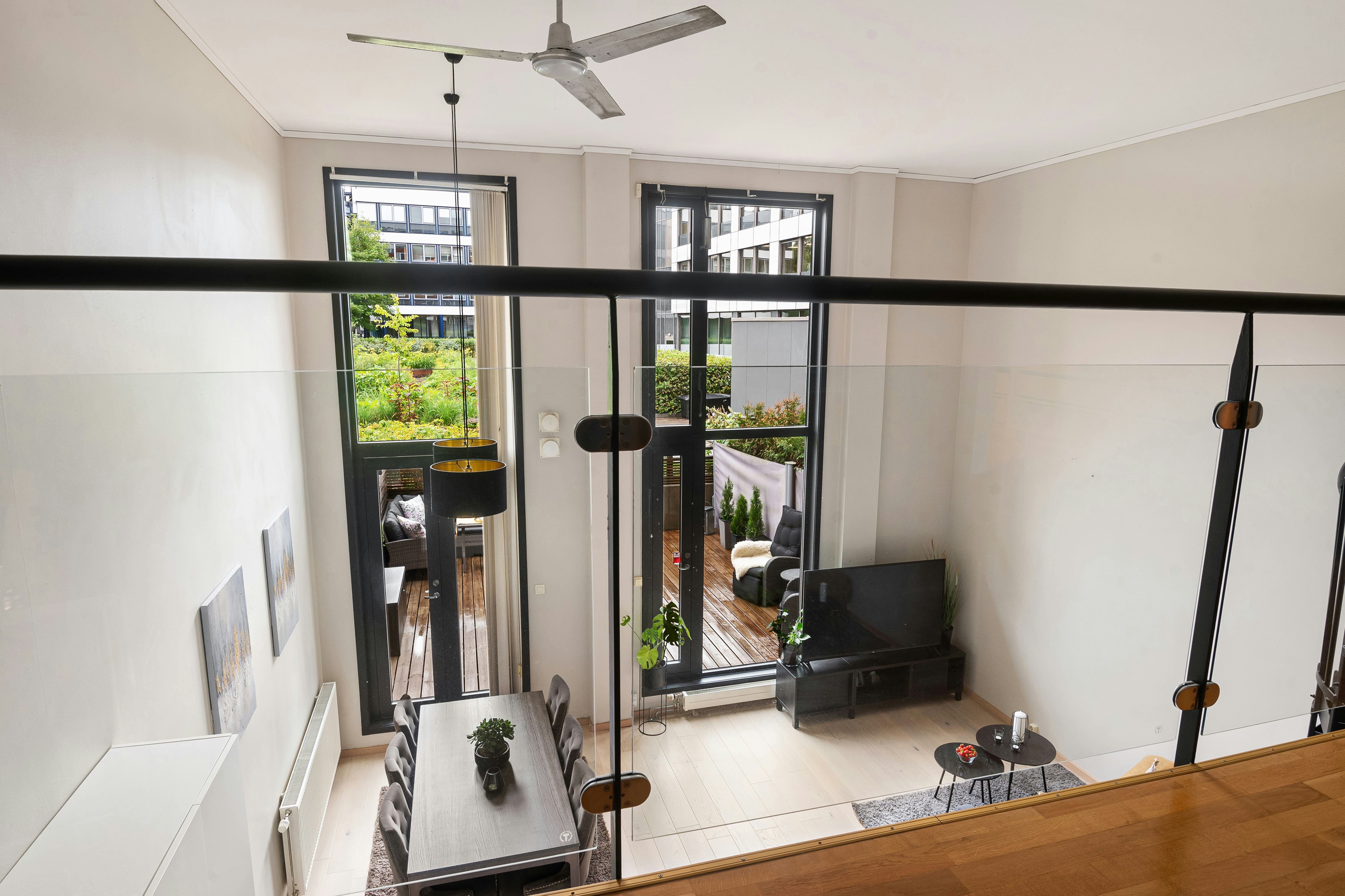 Loft Interior: Sunlit Balcony Doorway Flanked by Glass Railings