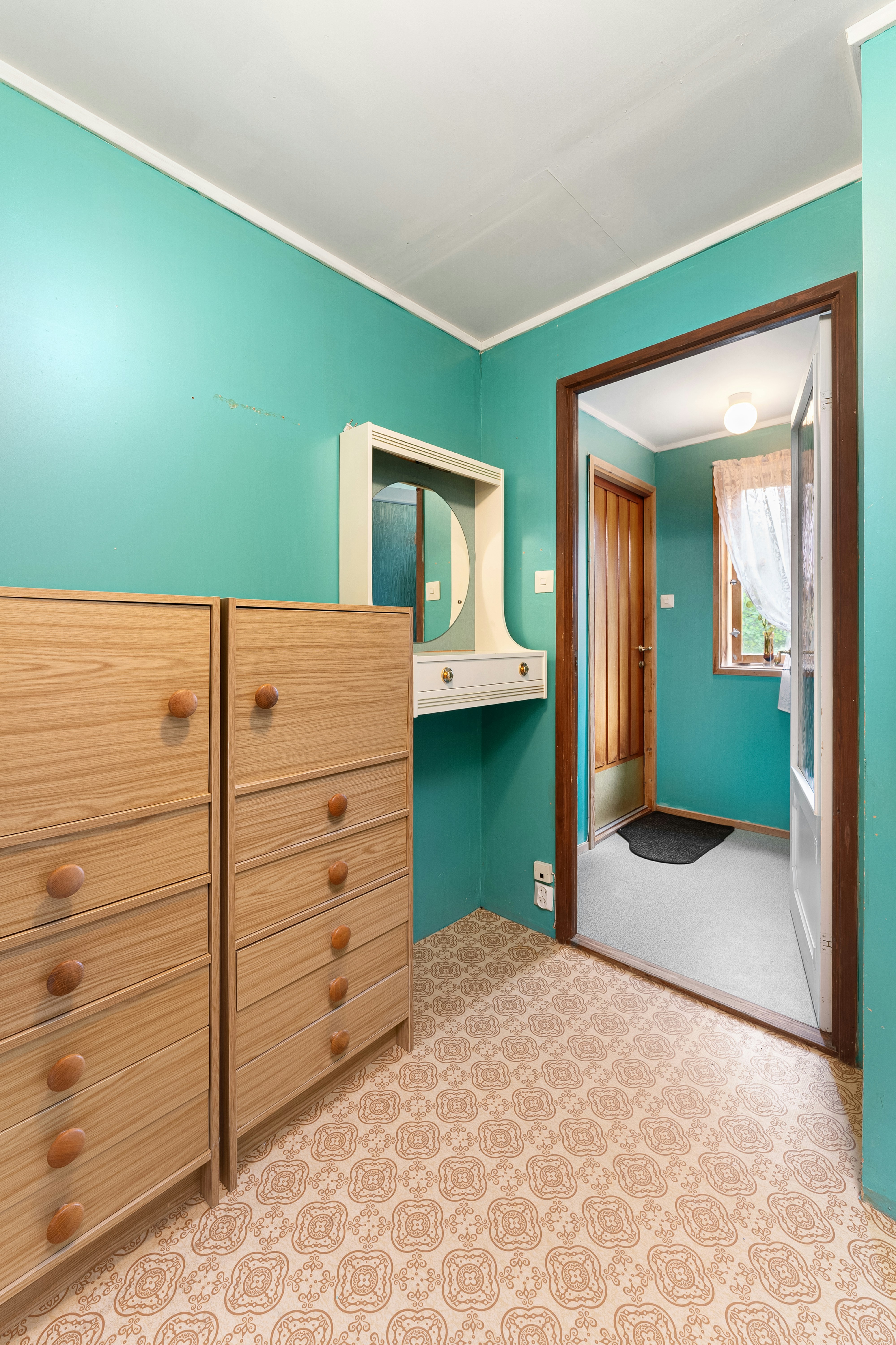 Teal Haven: Vintage Dressers Framing a Sunlit Vanity