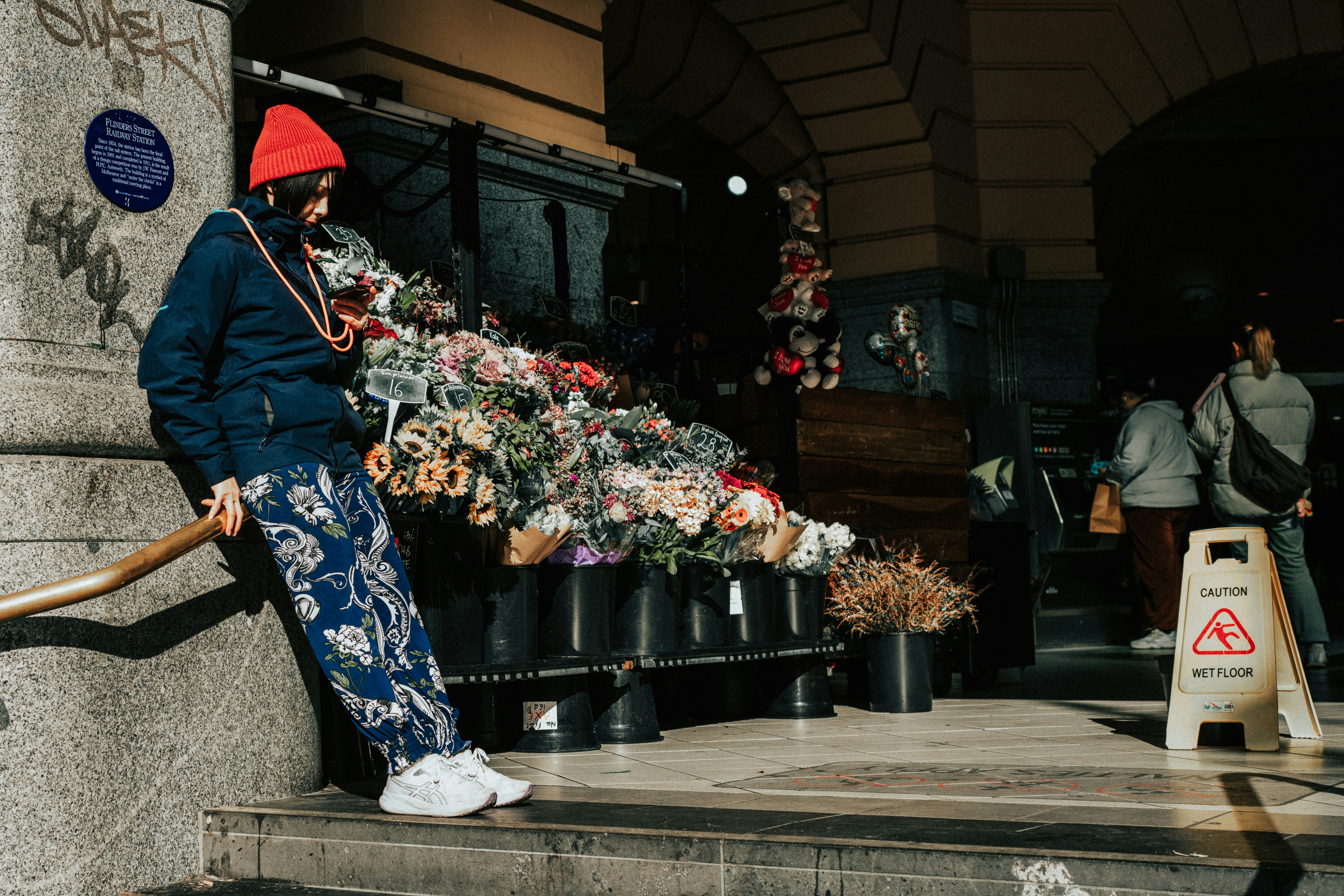 Street Vendor in Front of Flower Altar under Dim City Lights
