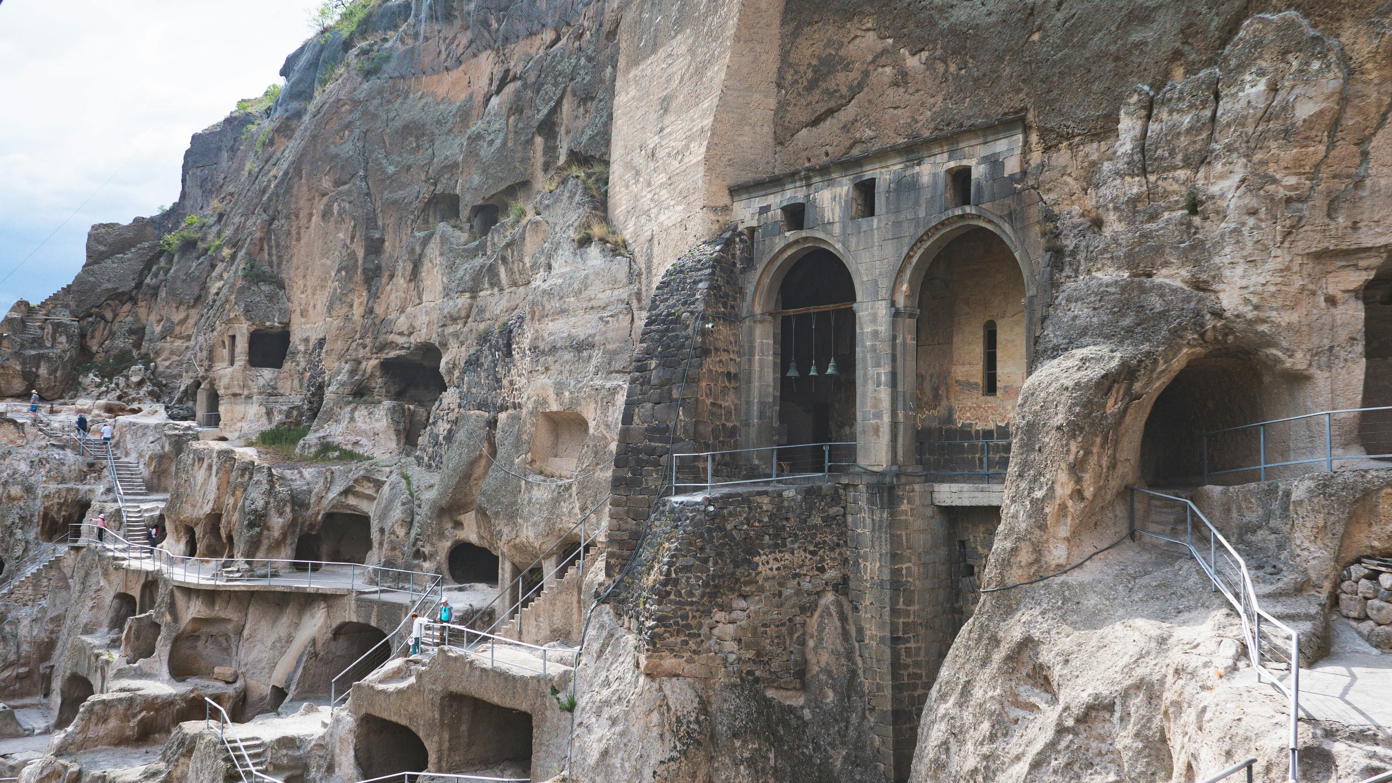 A large cliff with a bunch of buildings built into it photo – Free ...