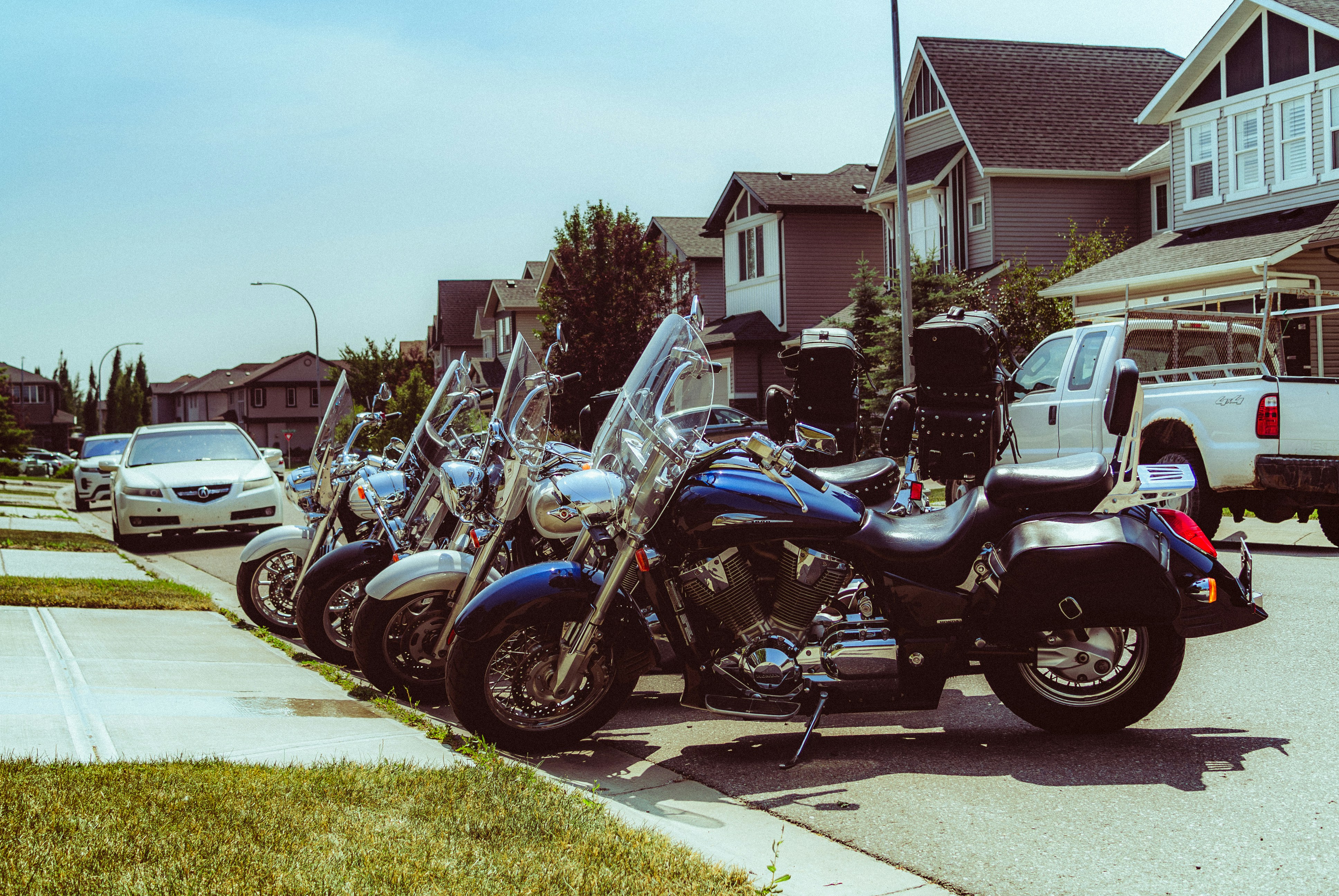 A row of motorcycles parked on the side of a road photo – Free ...