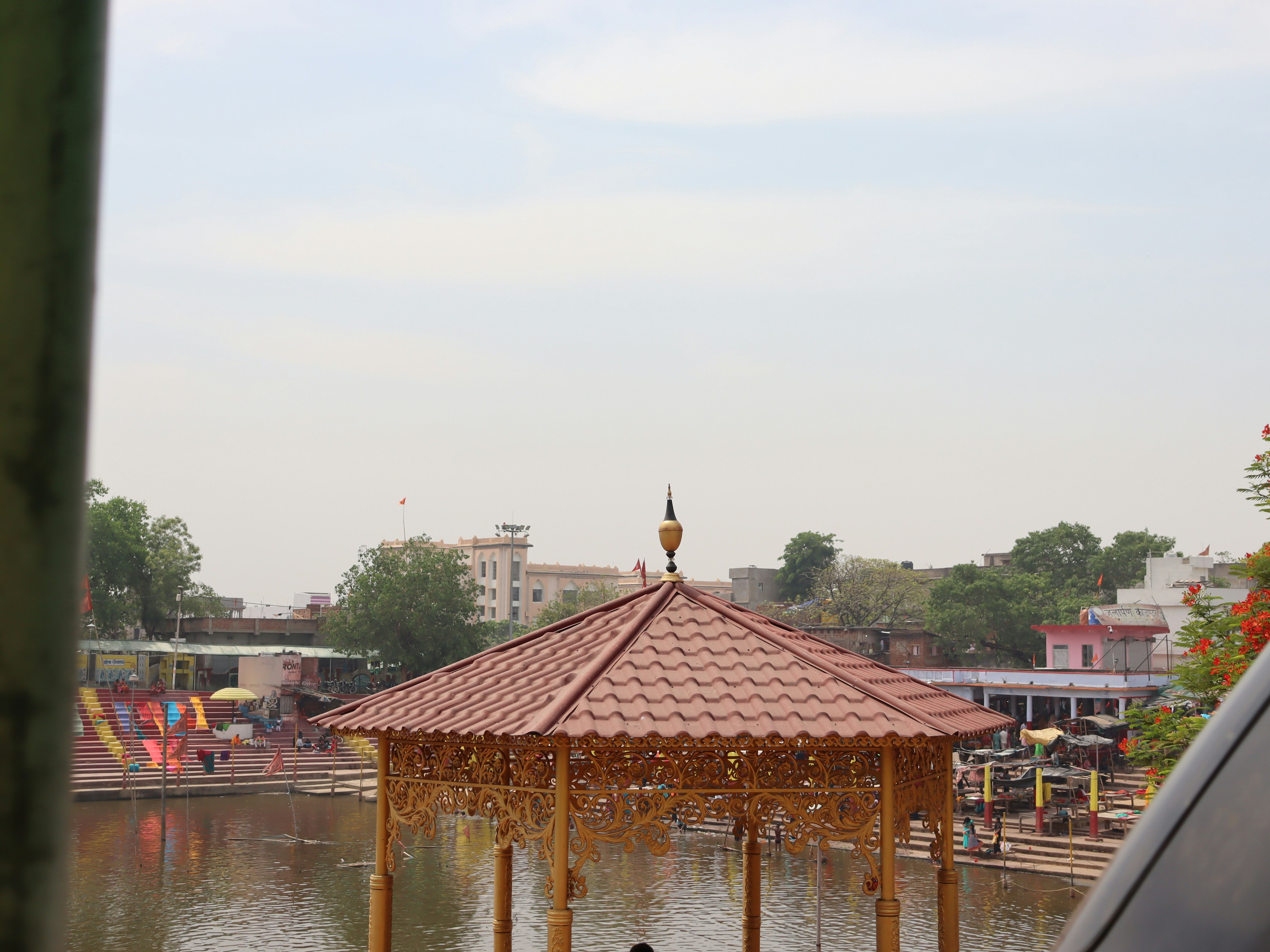 Riverside Gazebo in Warm Daylight: Golden Pavilion Framing a Busy Market