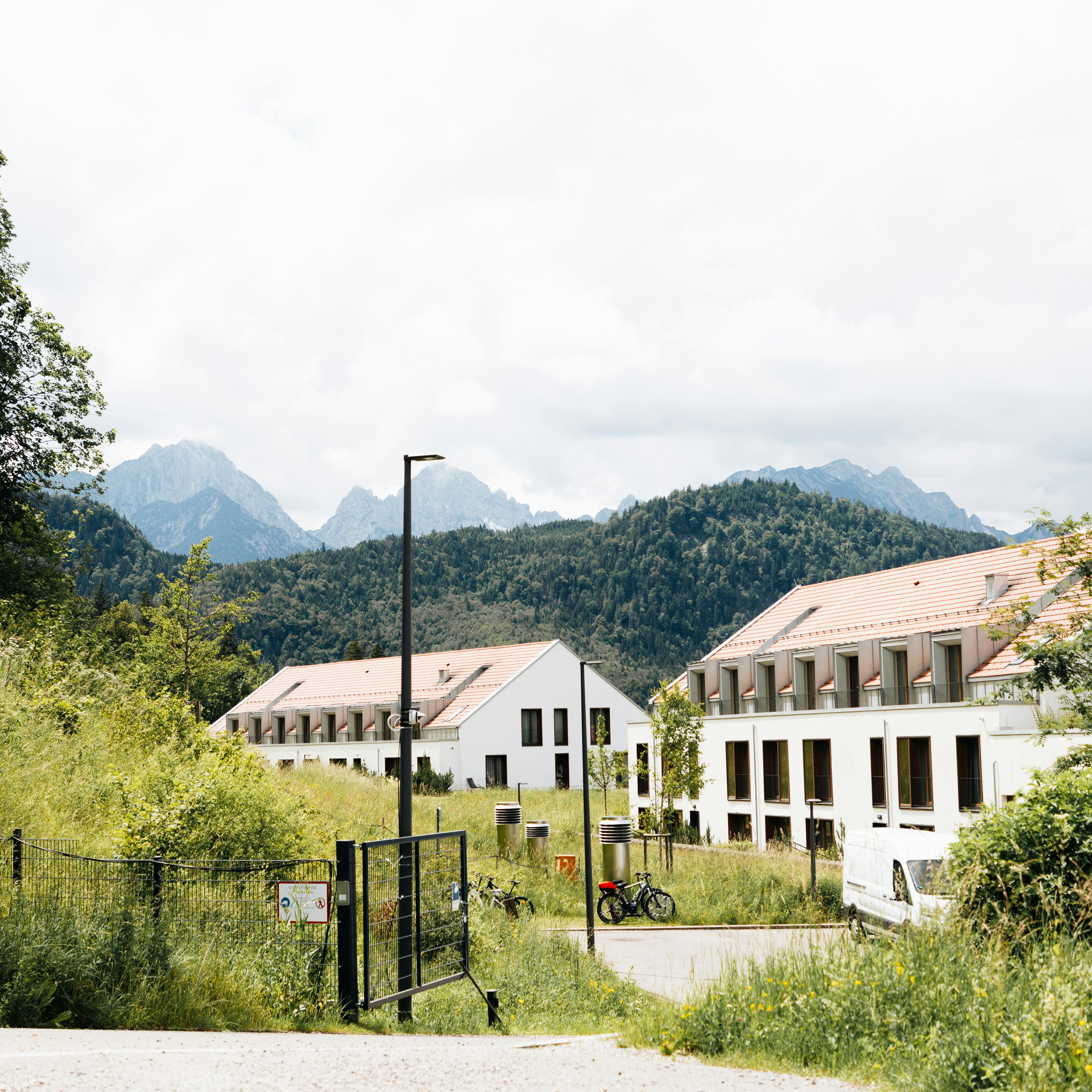 Alpine Campus: White-Set Buildings Framed by Distant Peaks