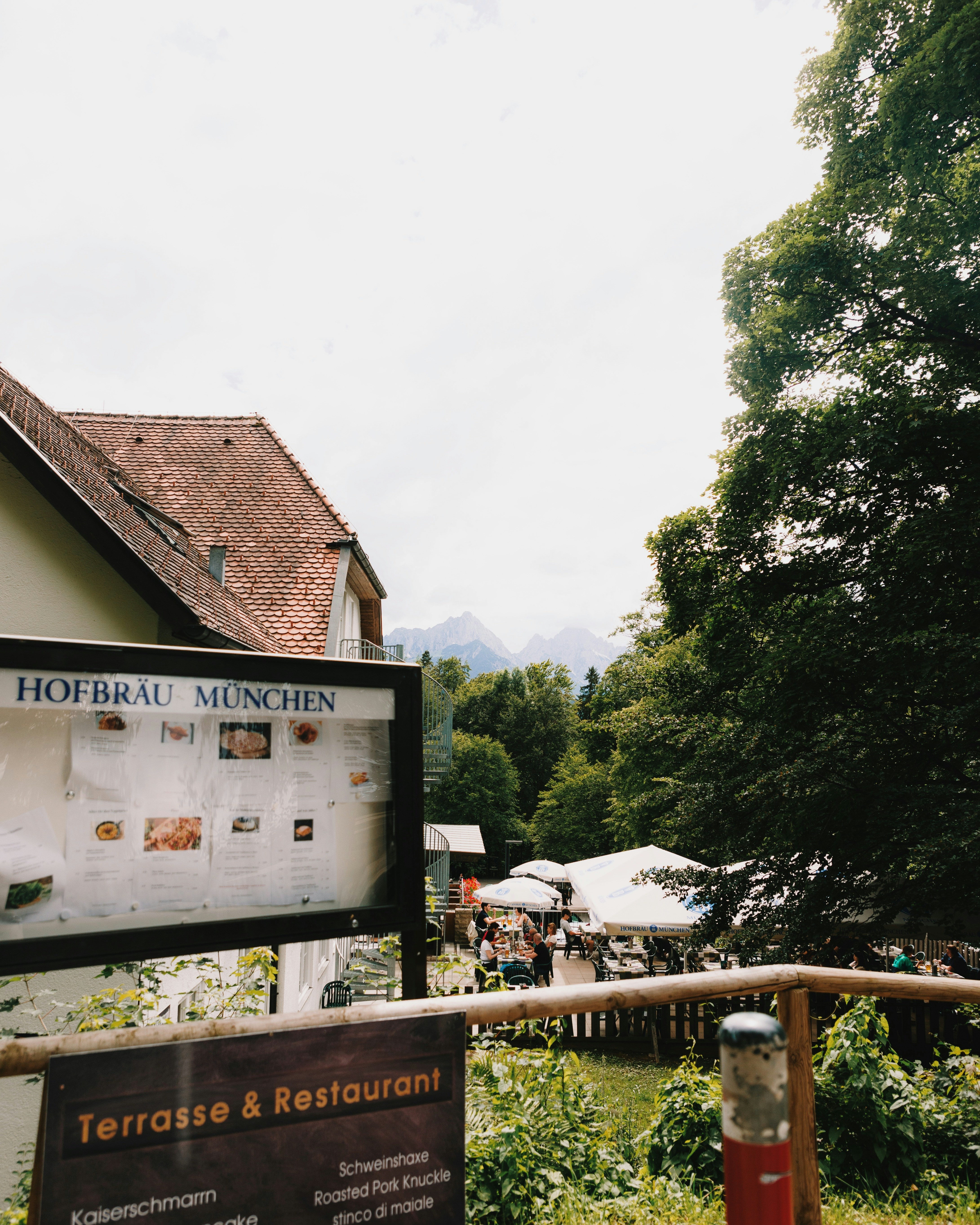 Terrasse & Restaurant: Bavarian beer garden framed by leaves and distant Alps