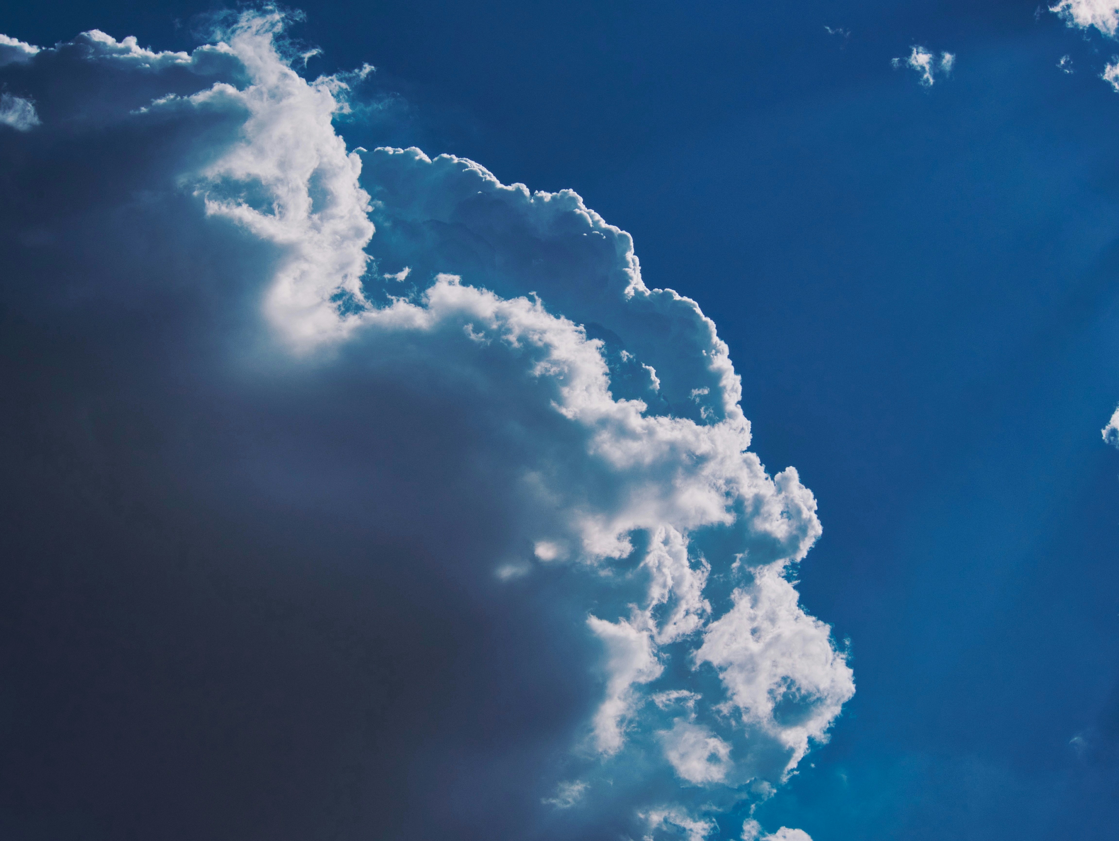 A plane flying through a blue cloudy sky photo – Free Nature Image on ...