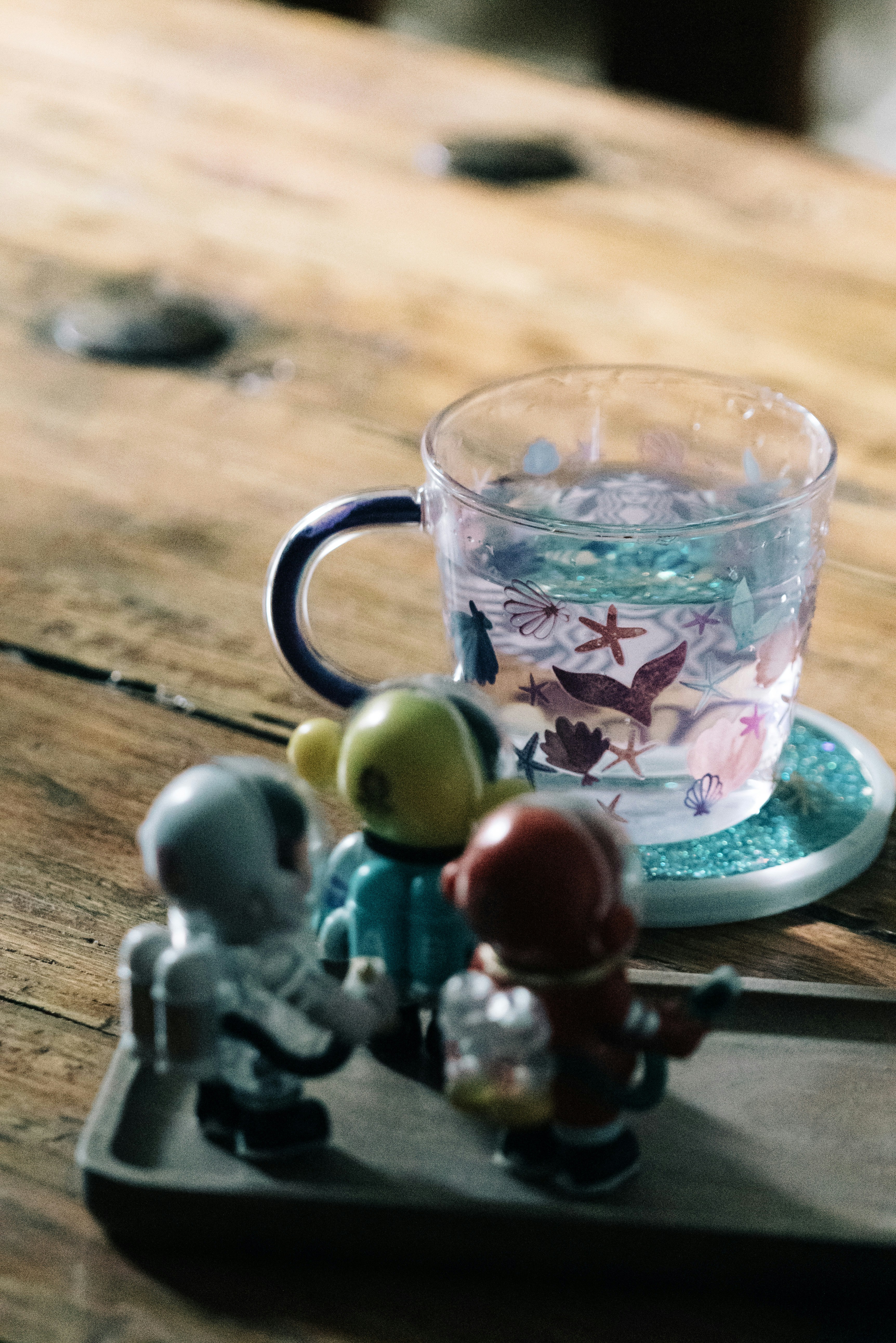 Sea-Patterned Glass Guarded by a Tiny Crew on Weathered Wood