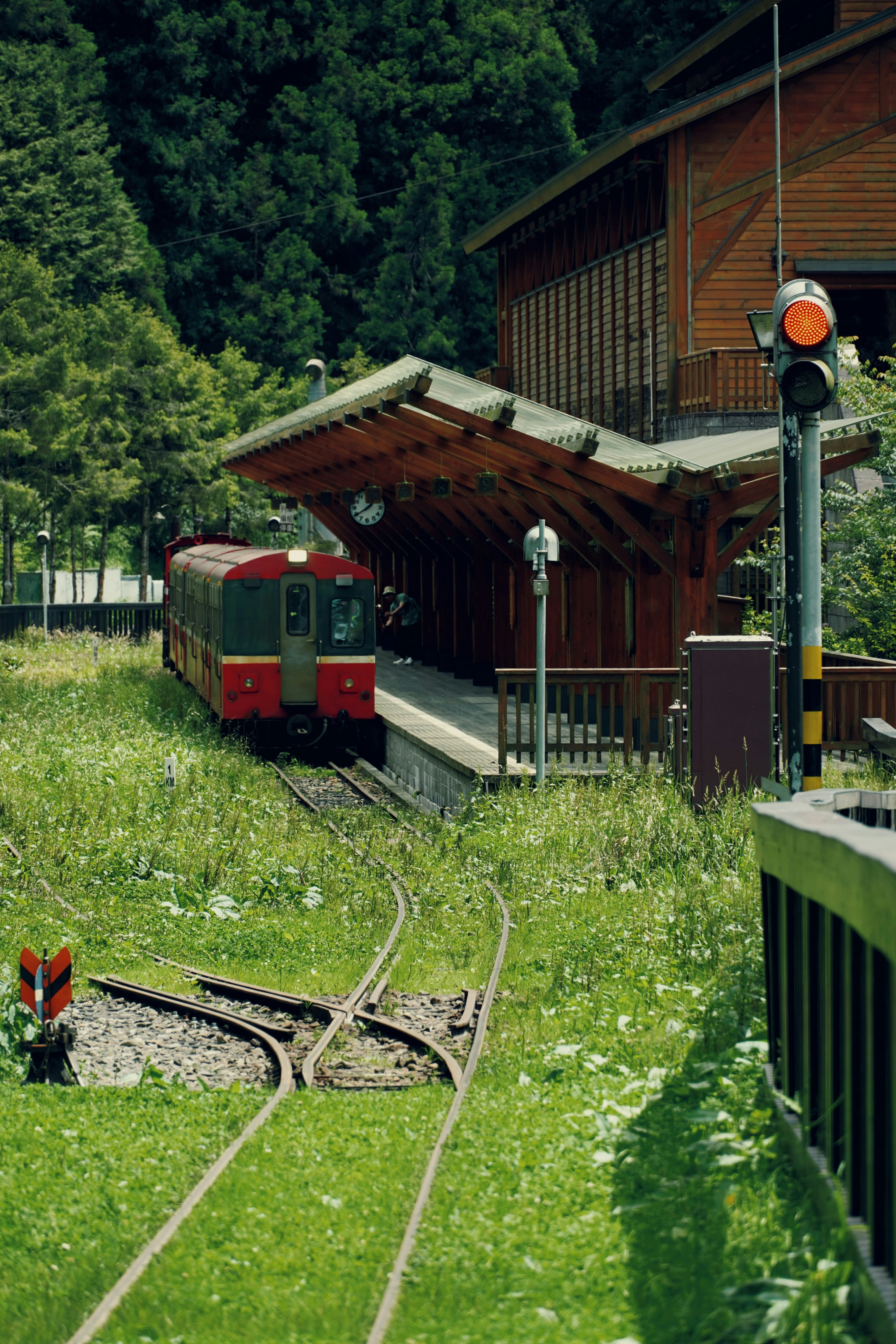 A train traveling down train tracks next to a building photo – Free ...