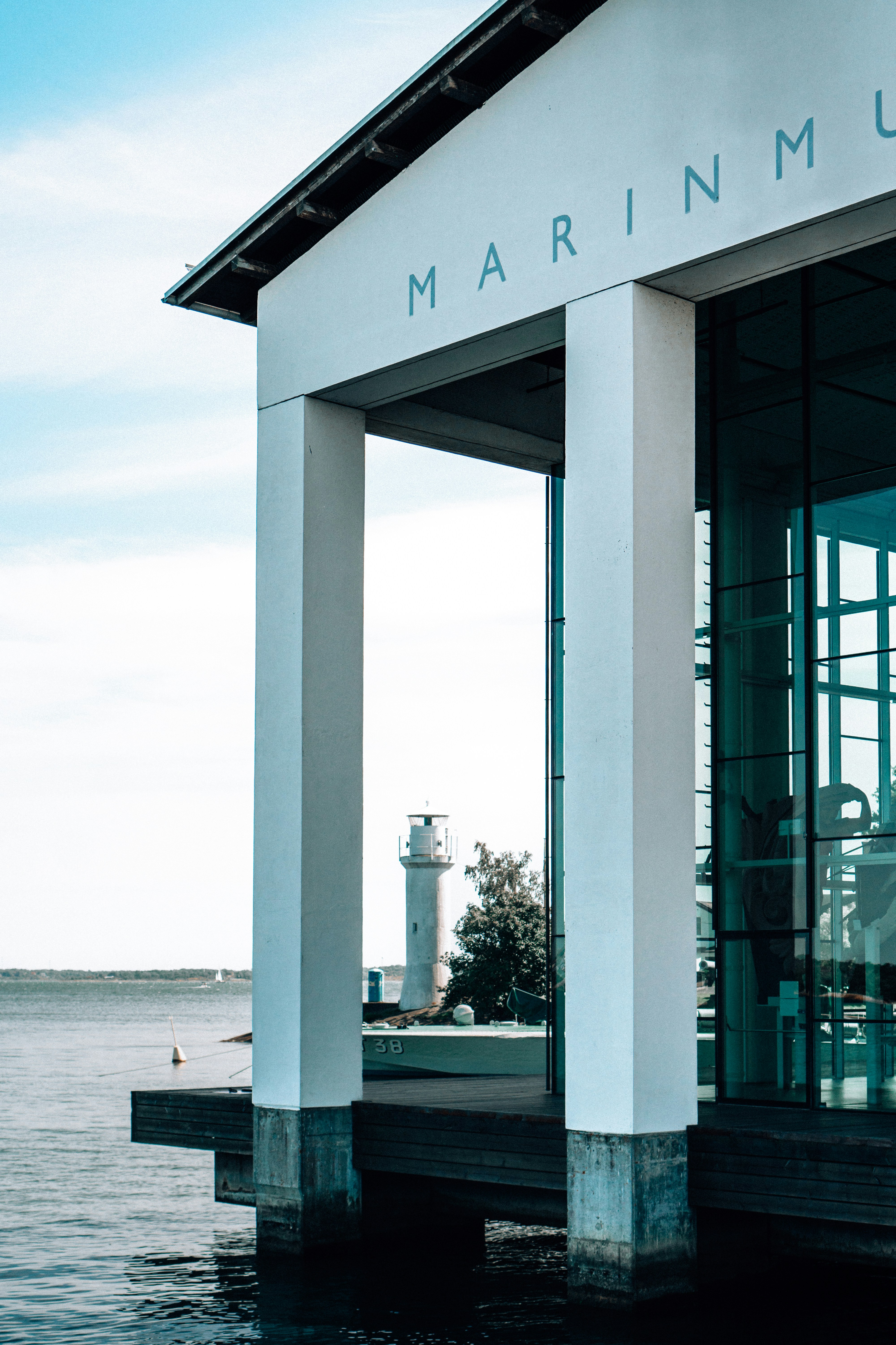 Arched Marina Pavilion Framing a Distant Lighthouse