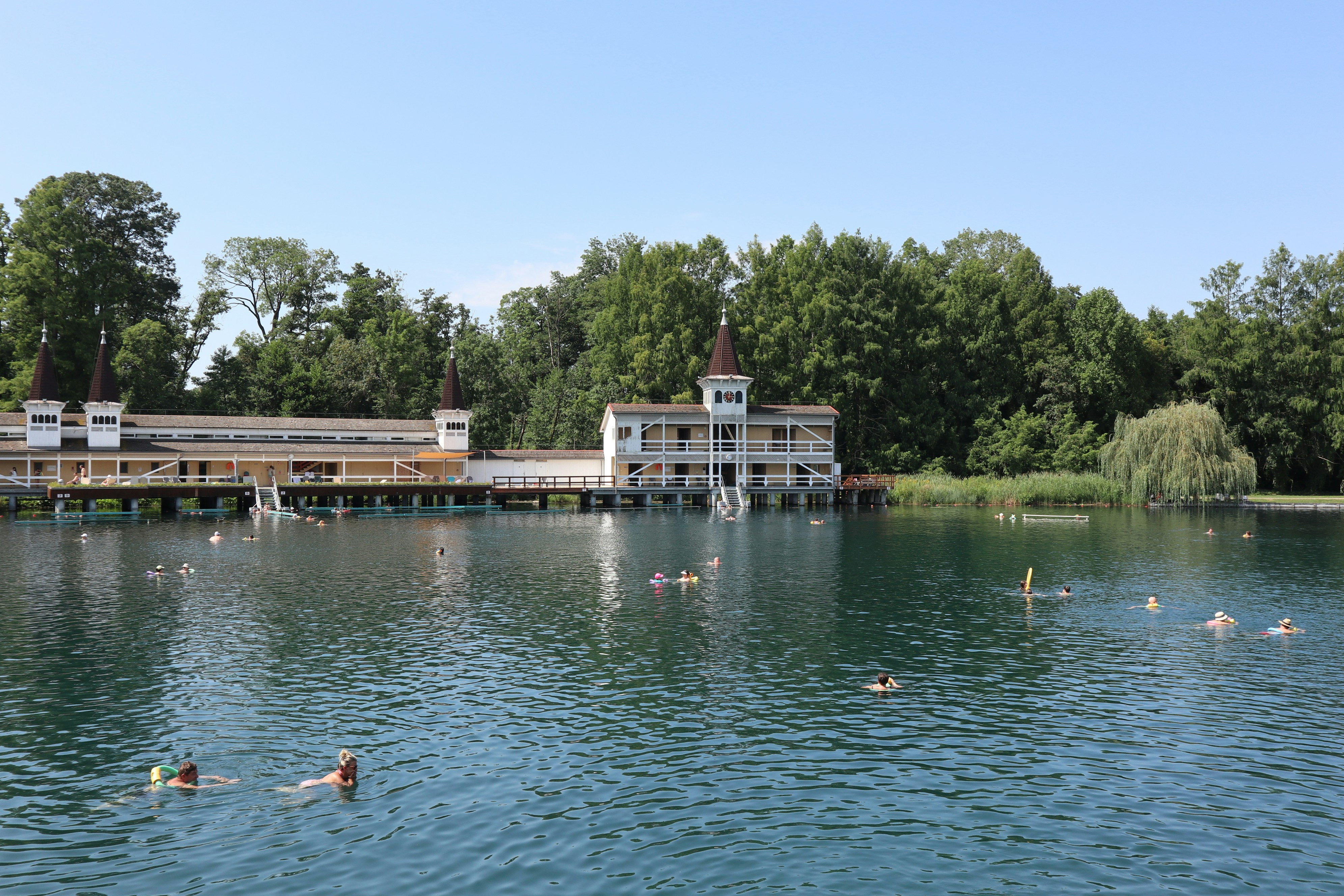 Boathouse Row by a Tranquil Lake: Morning Ripples and Towers