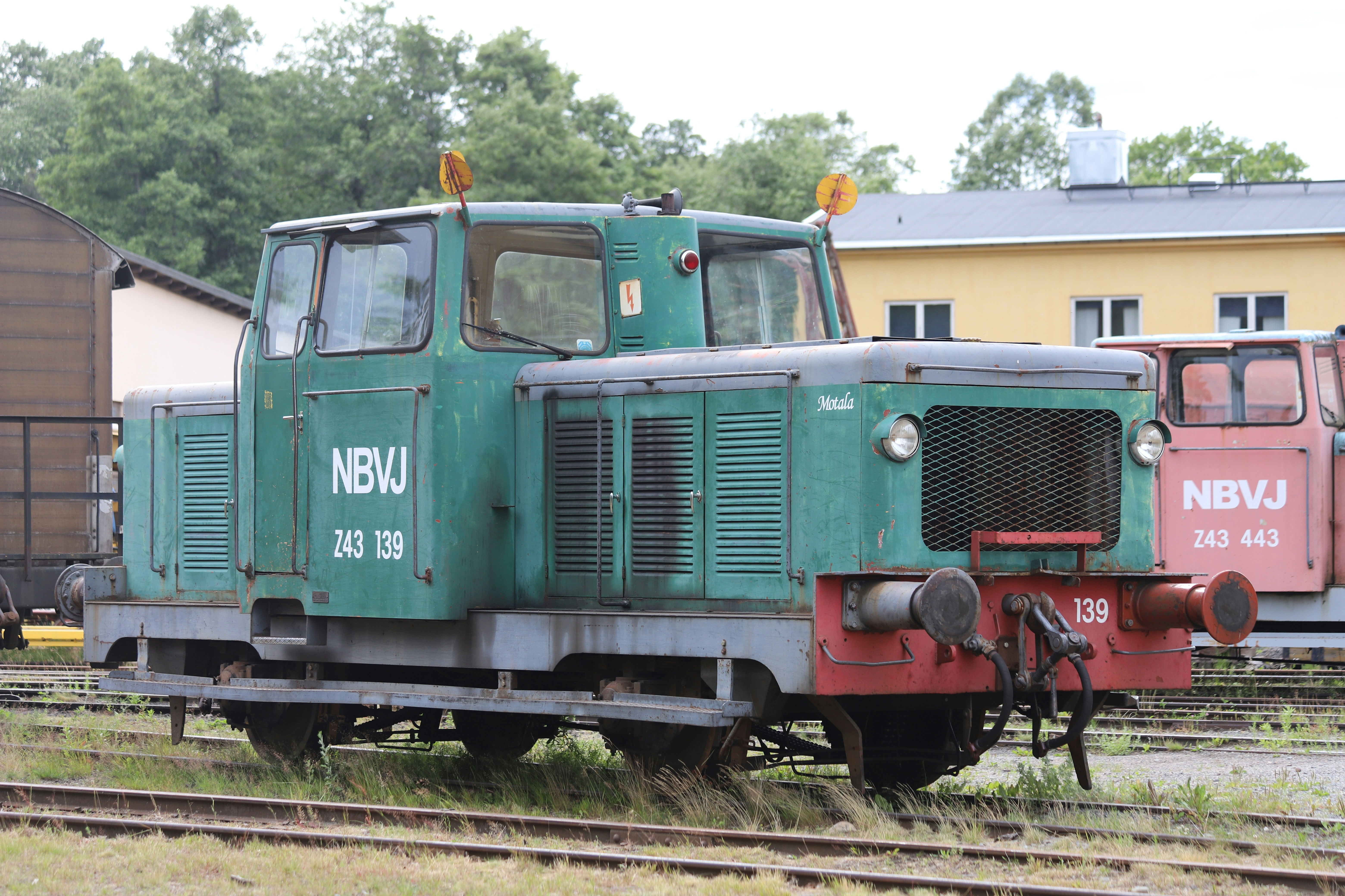A green and red truck sitting on top of train tracks photo – Free ...