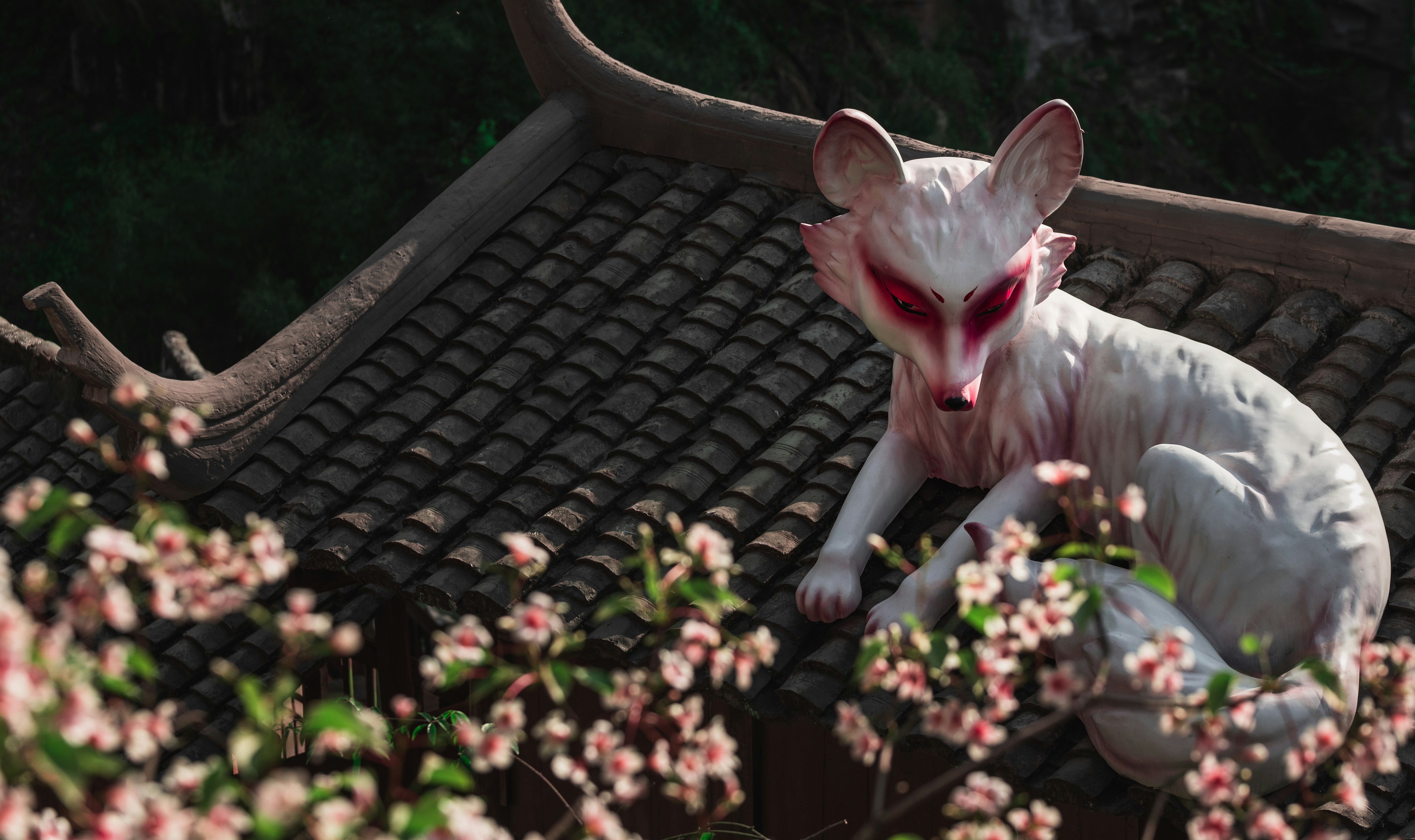 Crimson-eyed Fox Guardian on a Blossom-Kissed Roof