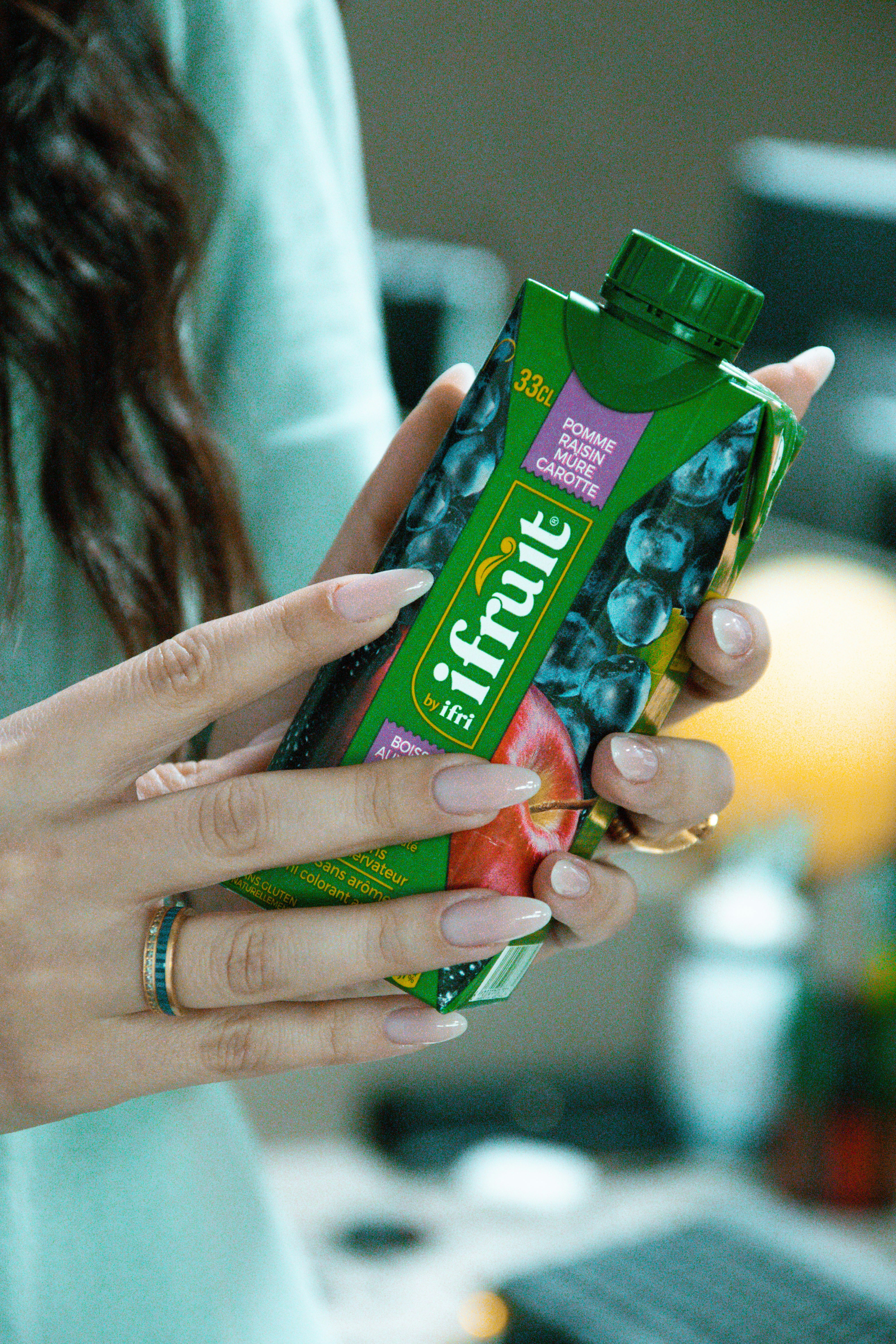 Fragrance of Fresh Juice: A Glimpse of a Green Fruit Carton in Hand
