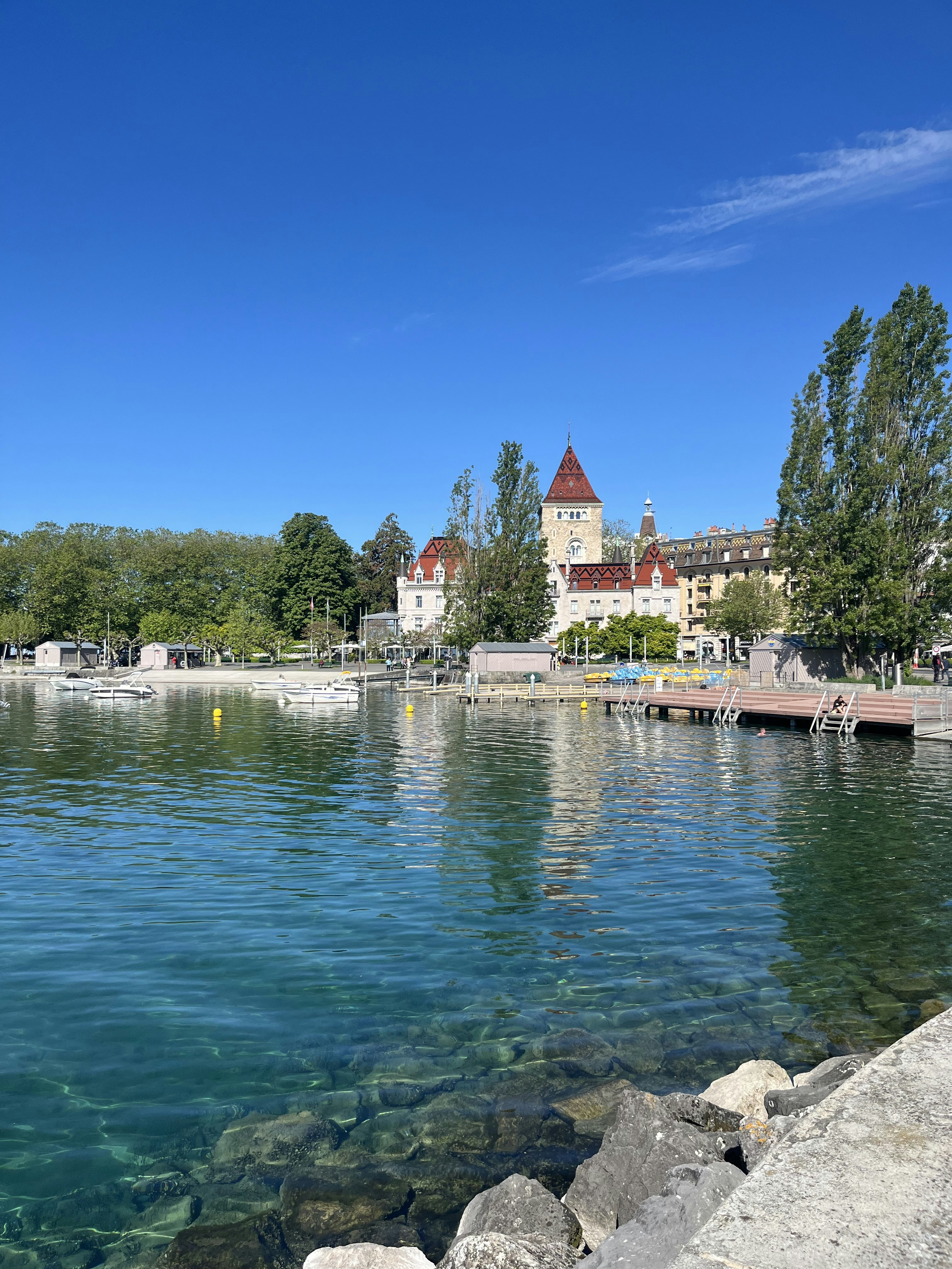 Turrets by the Lake: A Sunlit European Town Reflecting in Clear Water