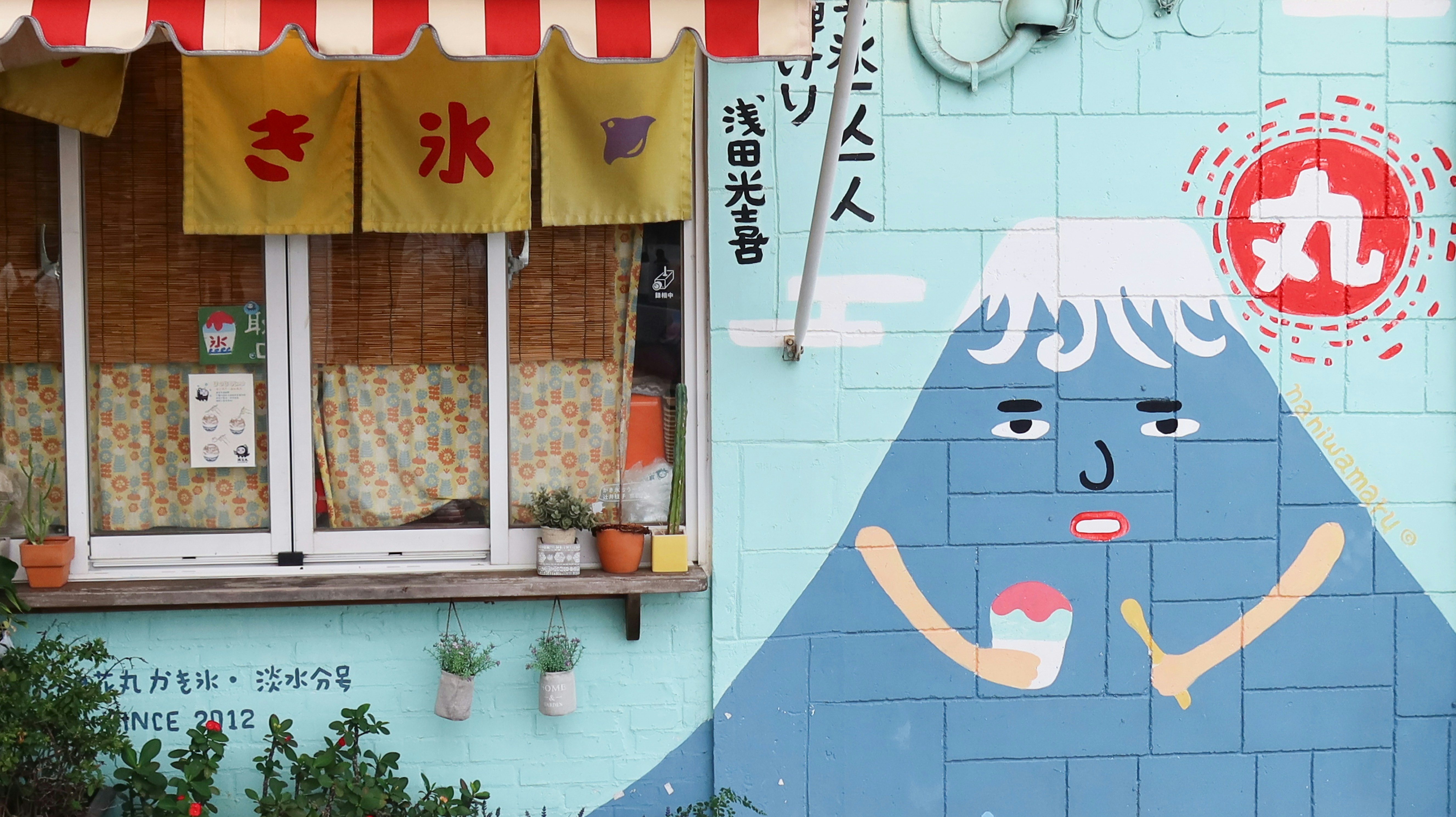 Tamsui, Taiwan - 21 October 2023: Naniwa Maru, near Hobe Fishing Harbor on Zhongzheng Rd, offers Japanese kakigori. The highlight is a cartoon iceberg holding a cup of shaved ice painted on the wall.