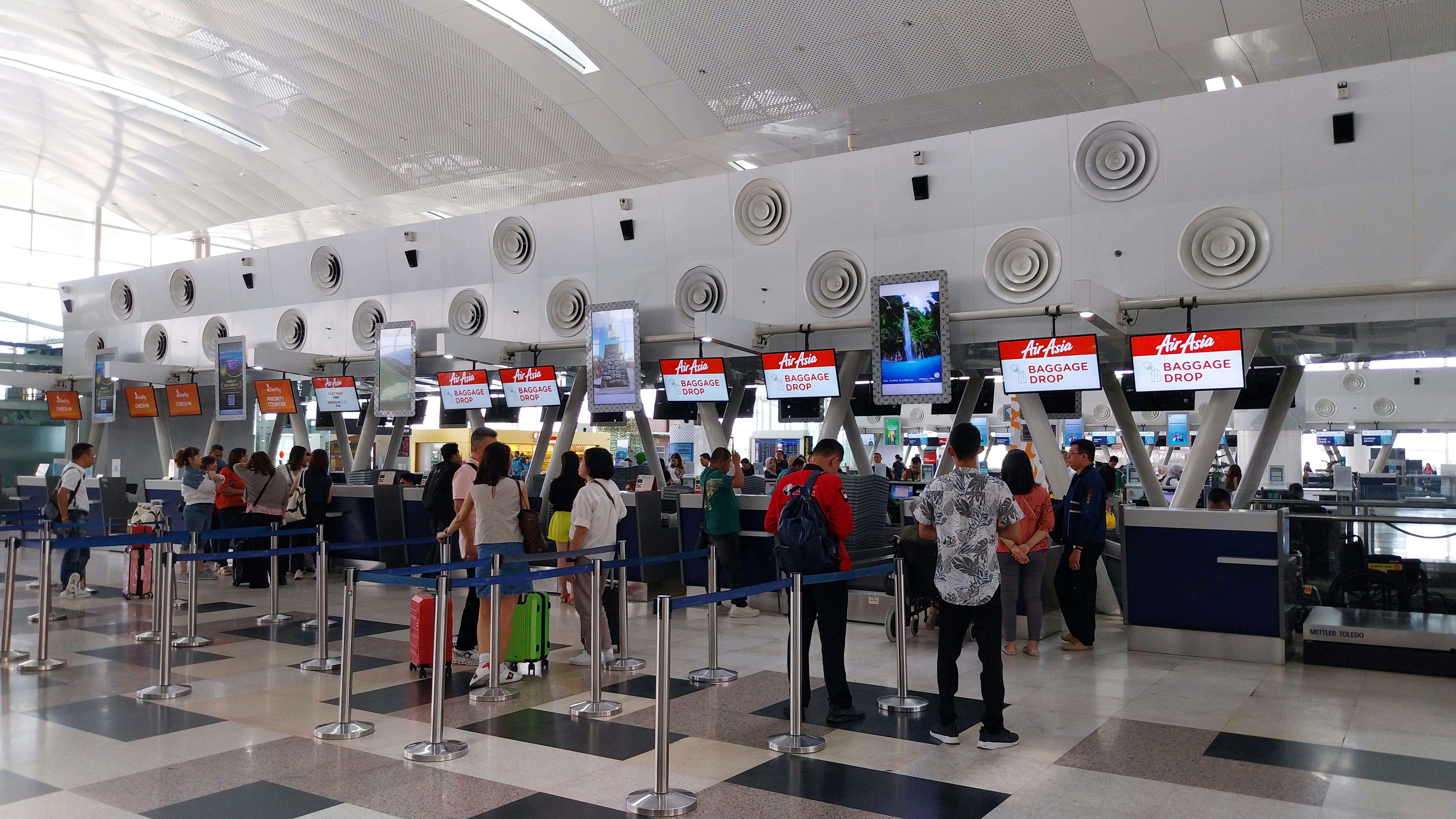A group of people waiting in line at an airport photo – Free Kualanamu ...