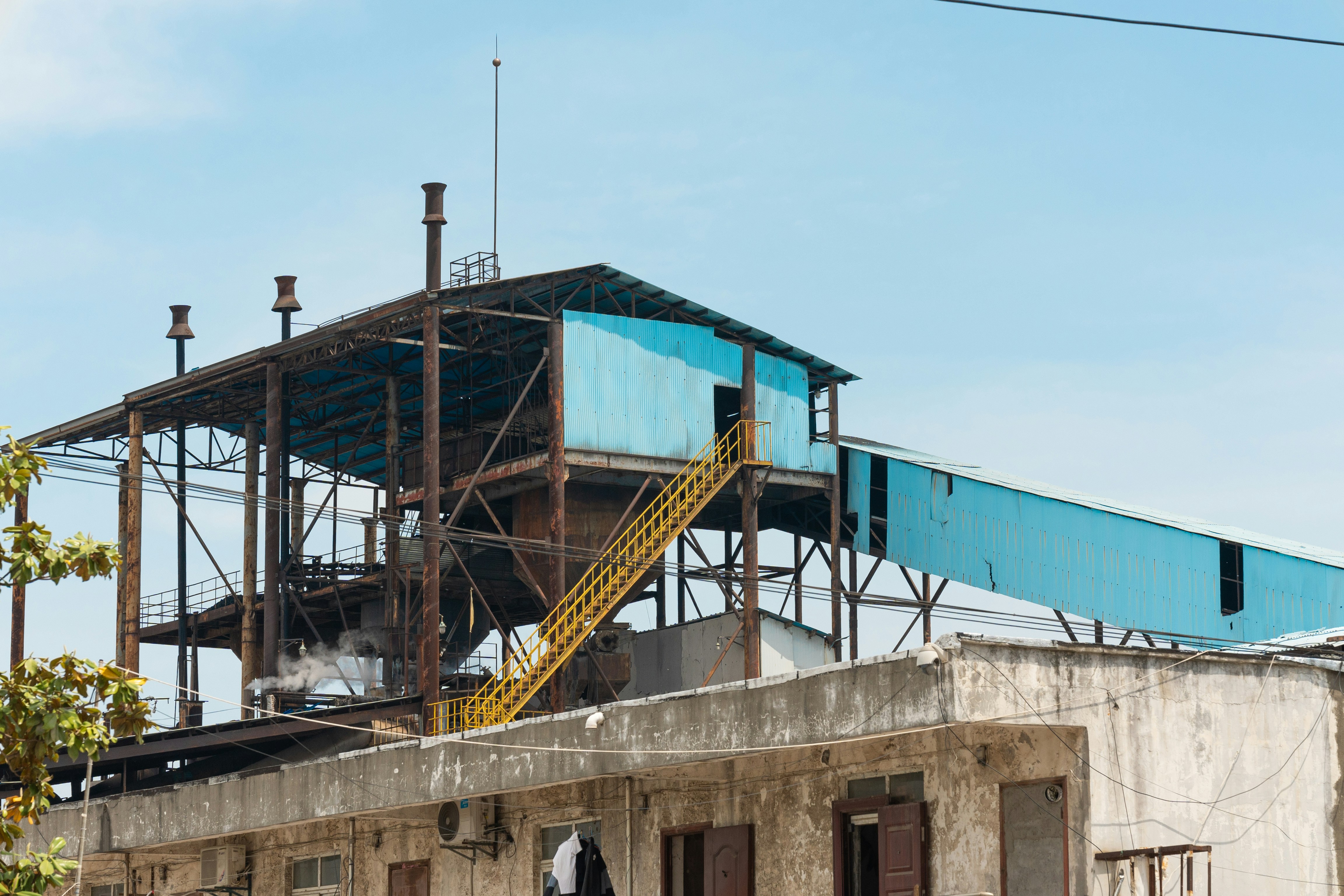 A building with a blue roof and a yellow ladder photo – Free ...
